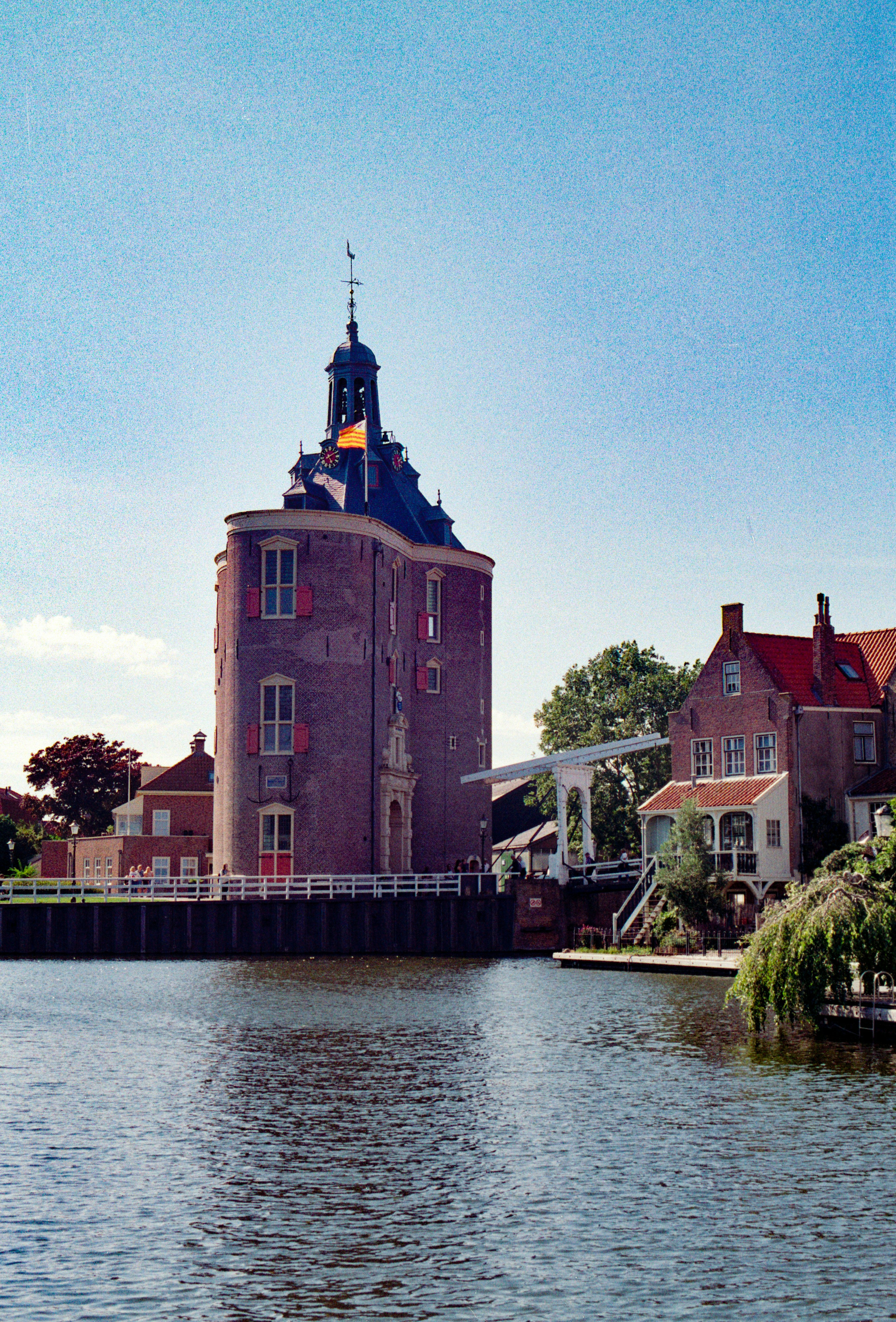 Brick tower building beside a calm body of water