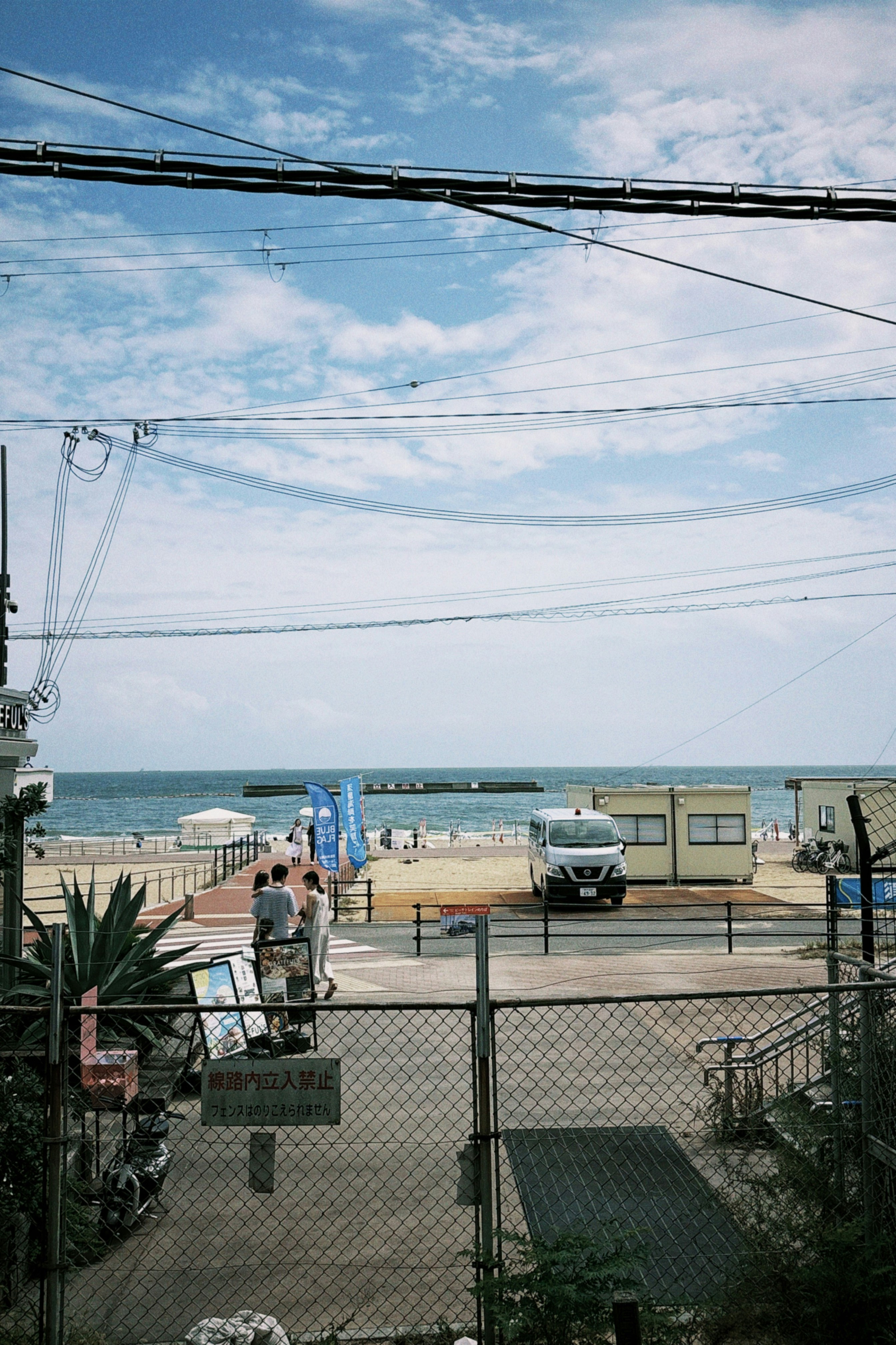 Beach scene with ocean, sand, and buildings