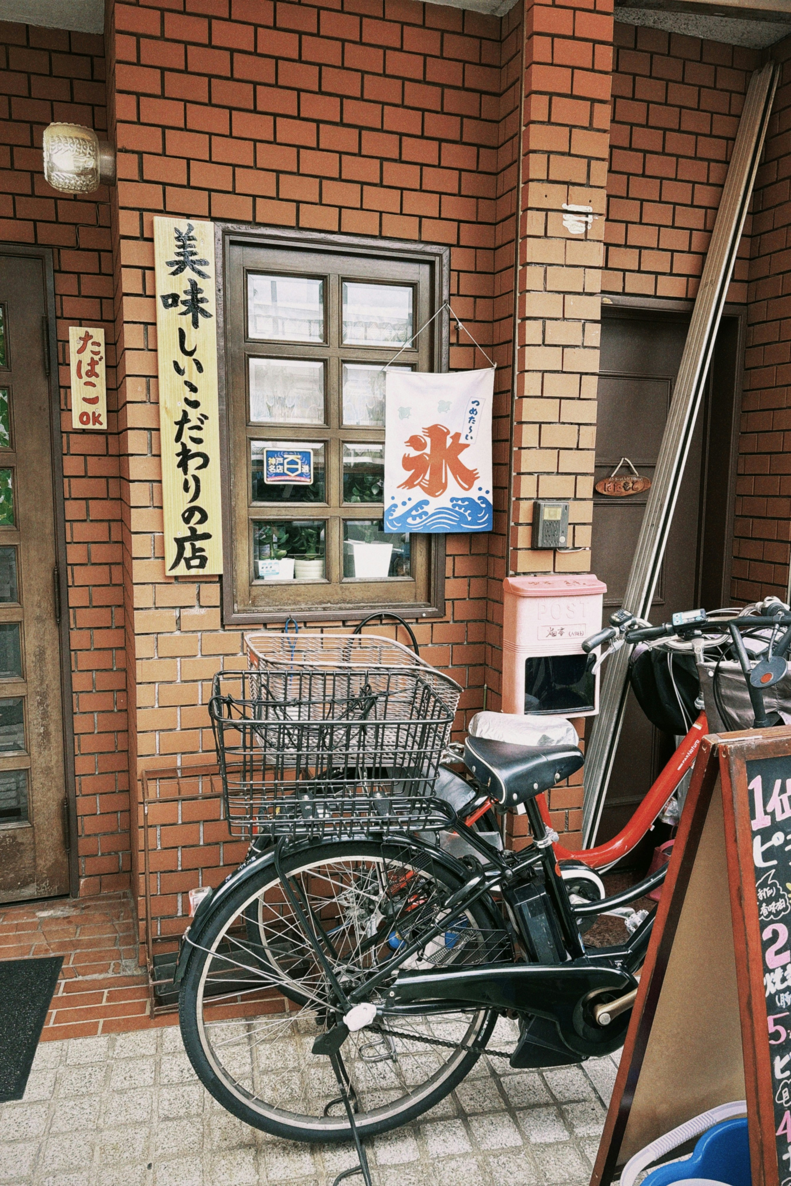 Bicycle parked outside a brick building with signage