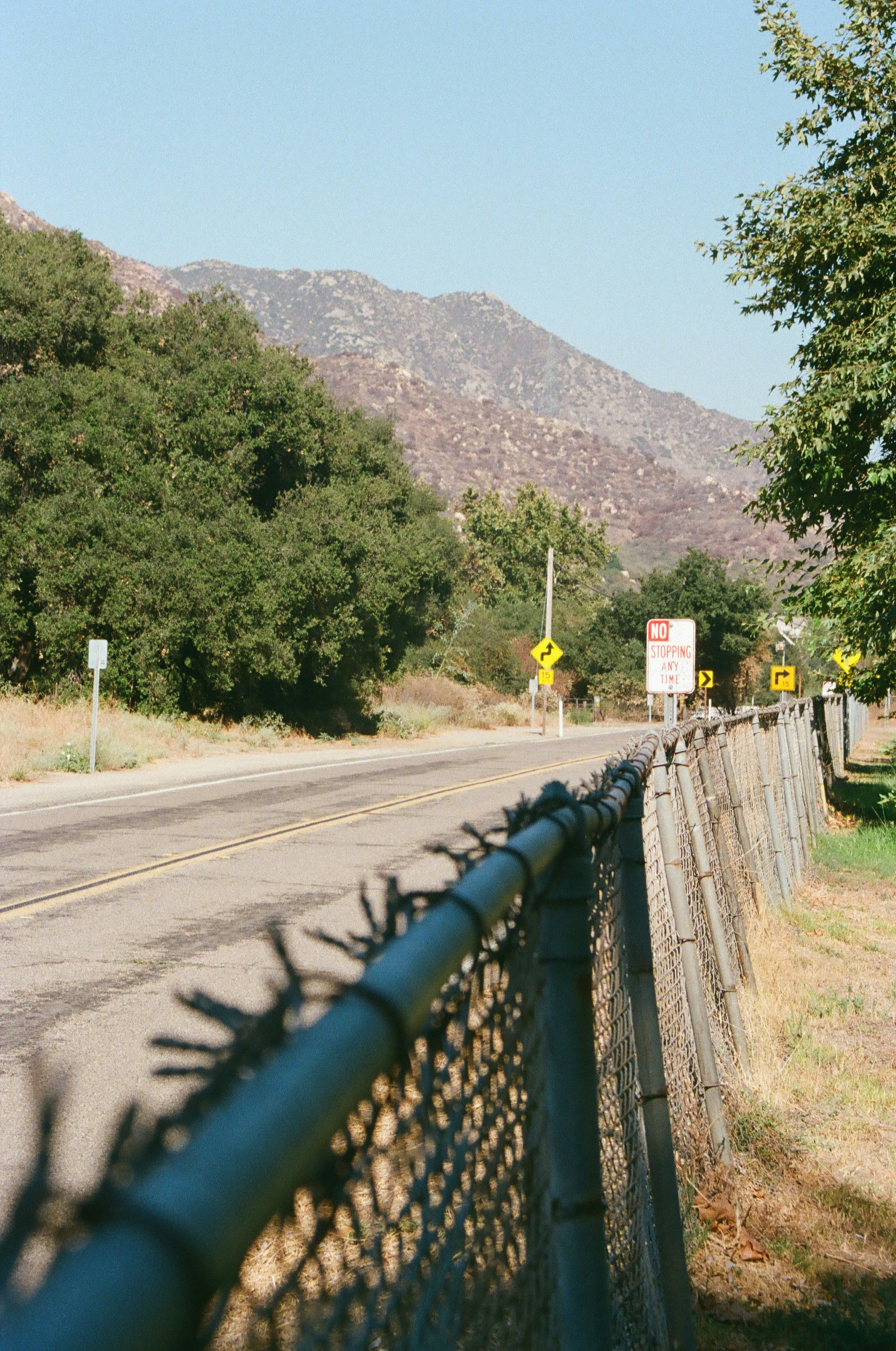 Roadside fence with trees and distant mountains photo – Free Road Image ...