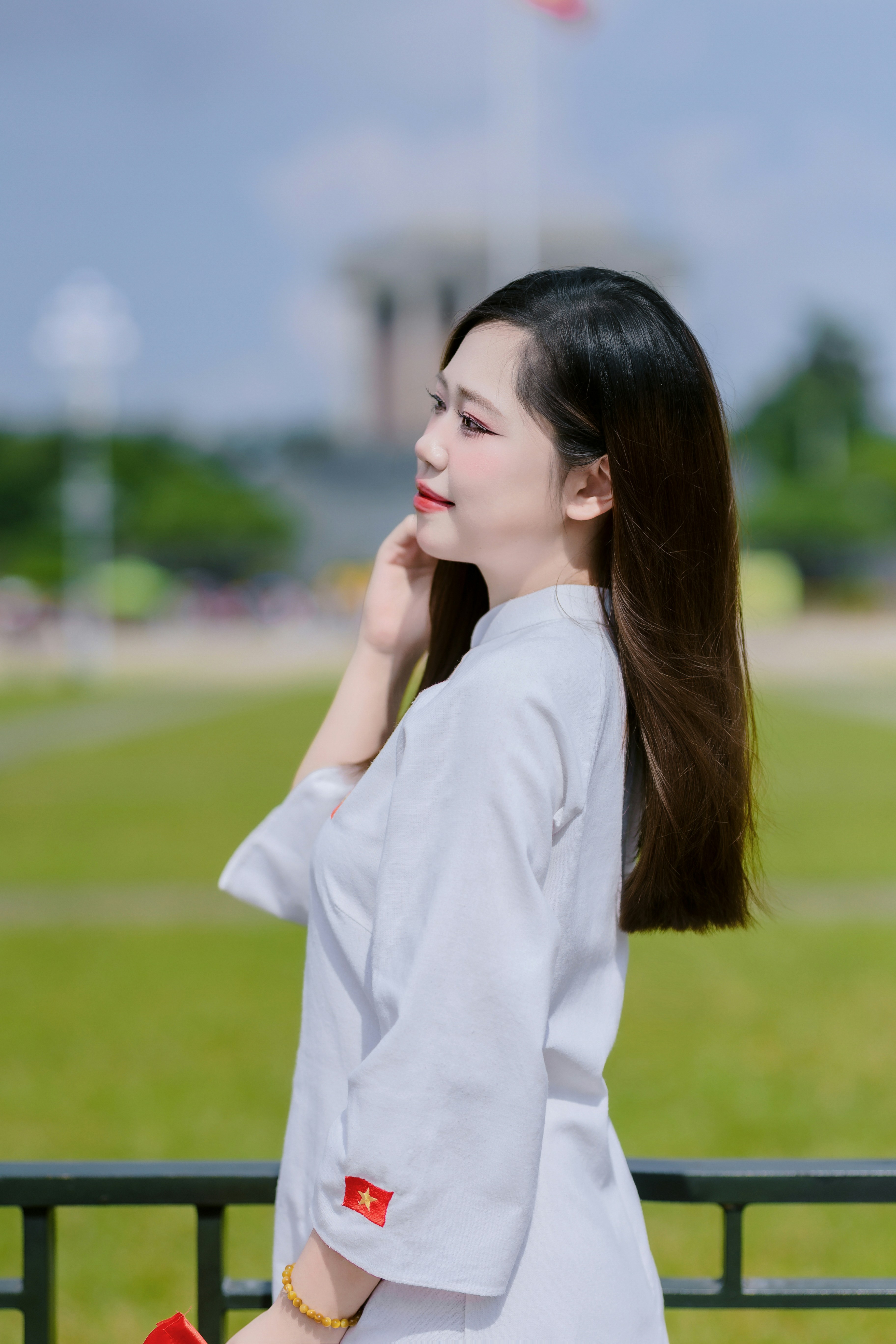 Vietnamese girl in ao dai celebrates national day | Young woman in white outfit with long dark hair.