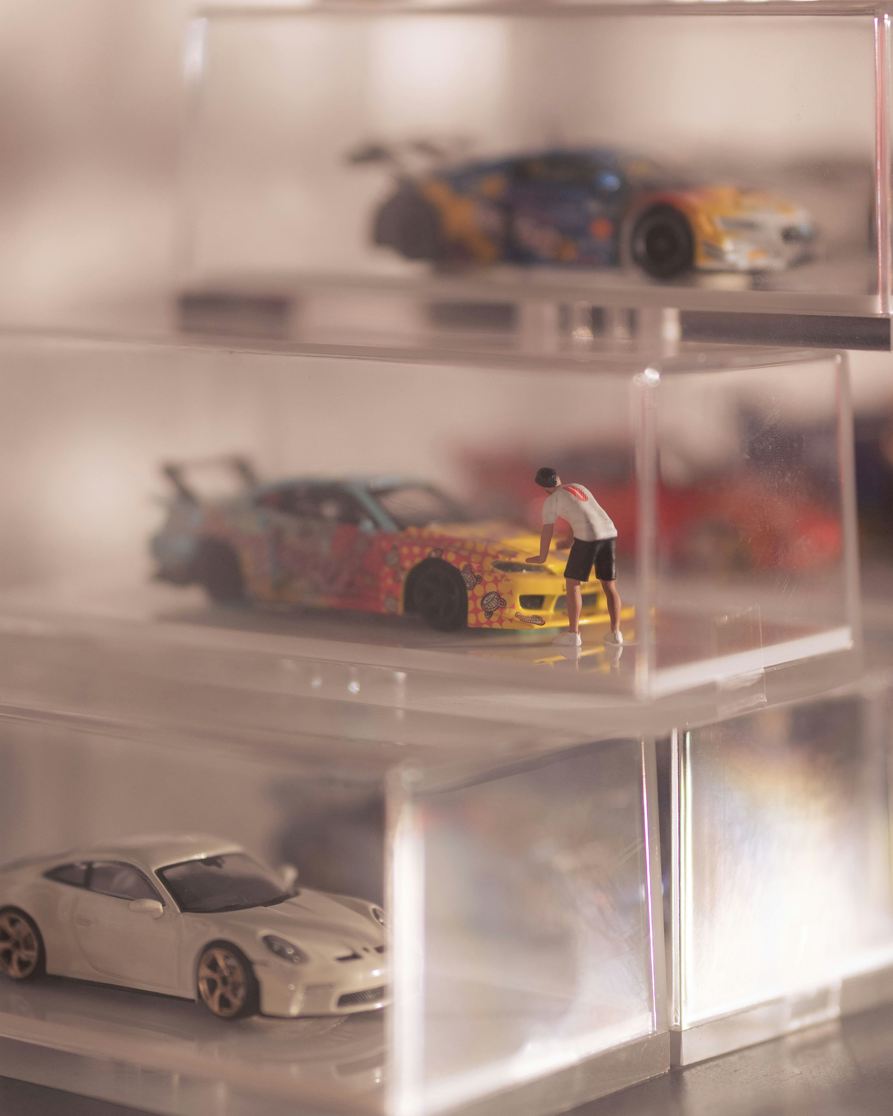 Glass-Garage Moment: A Tiny Pit Crew Attends a Yellow Racer