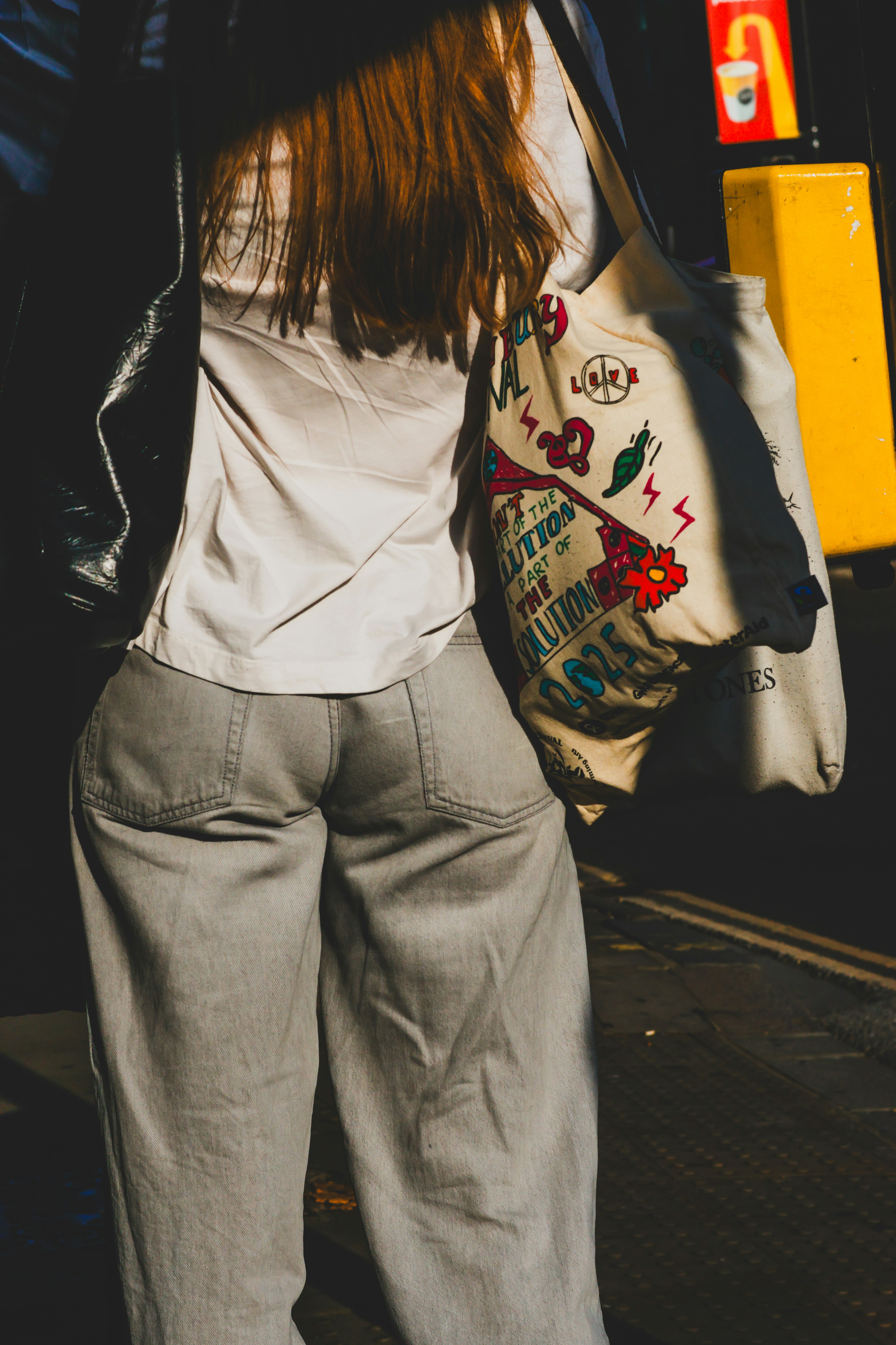 Woman wearing grey pants walking at night