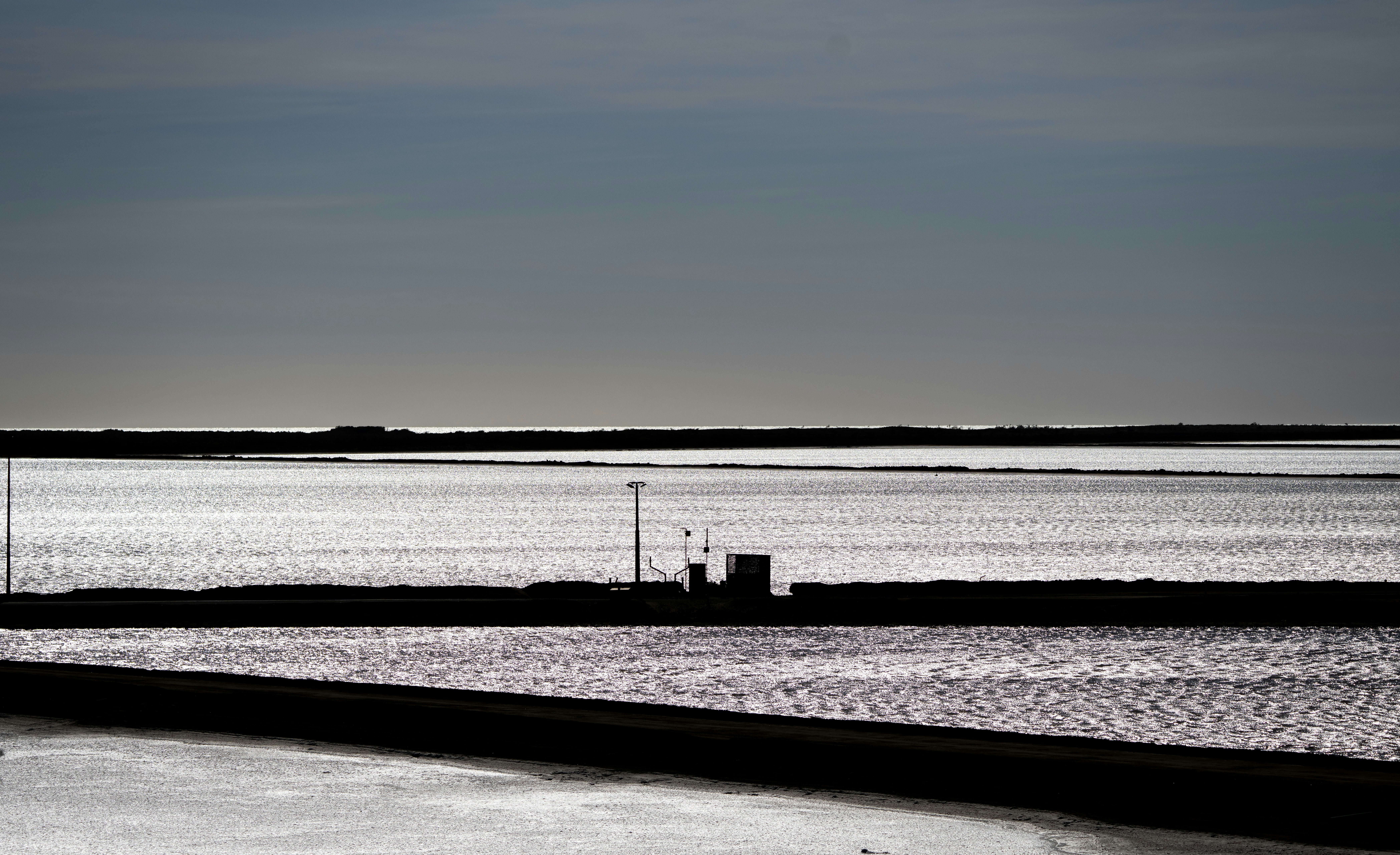 Snowy landscape with a distant figure and faint horizon.