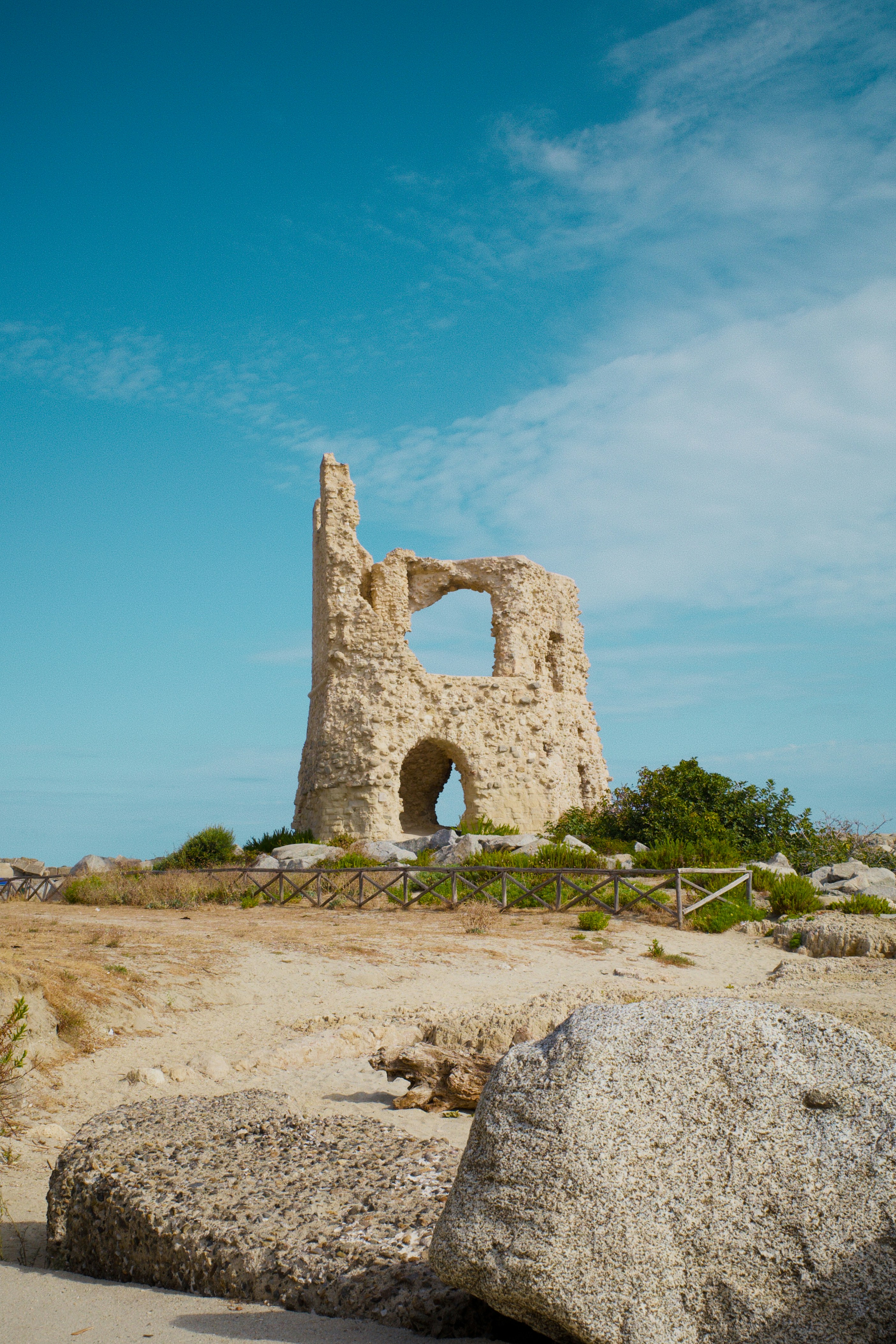 Ancient stone tower ruins against a clear blue sky.