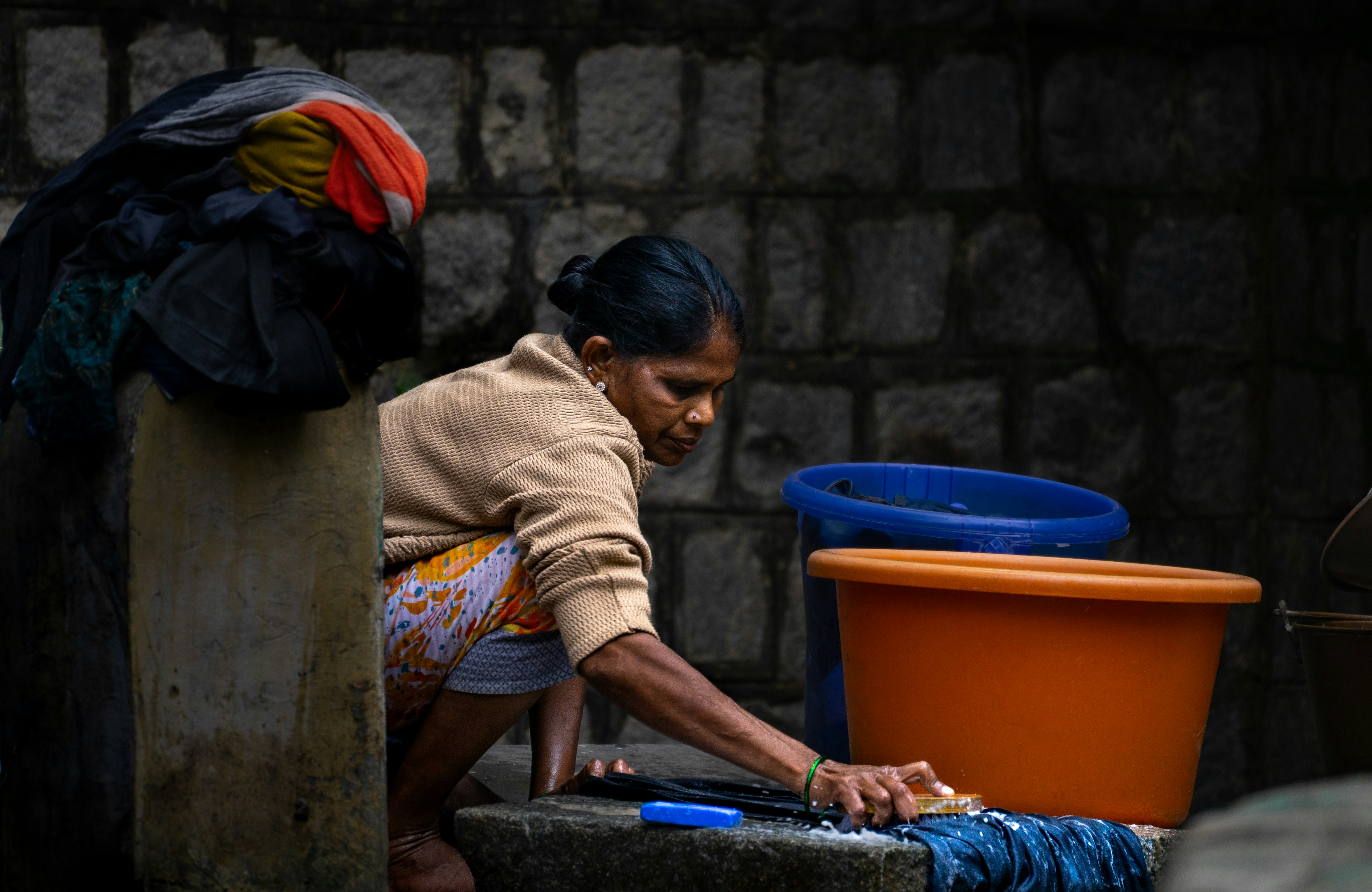Woman washing clothes with a scrub brush.