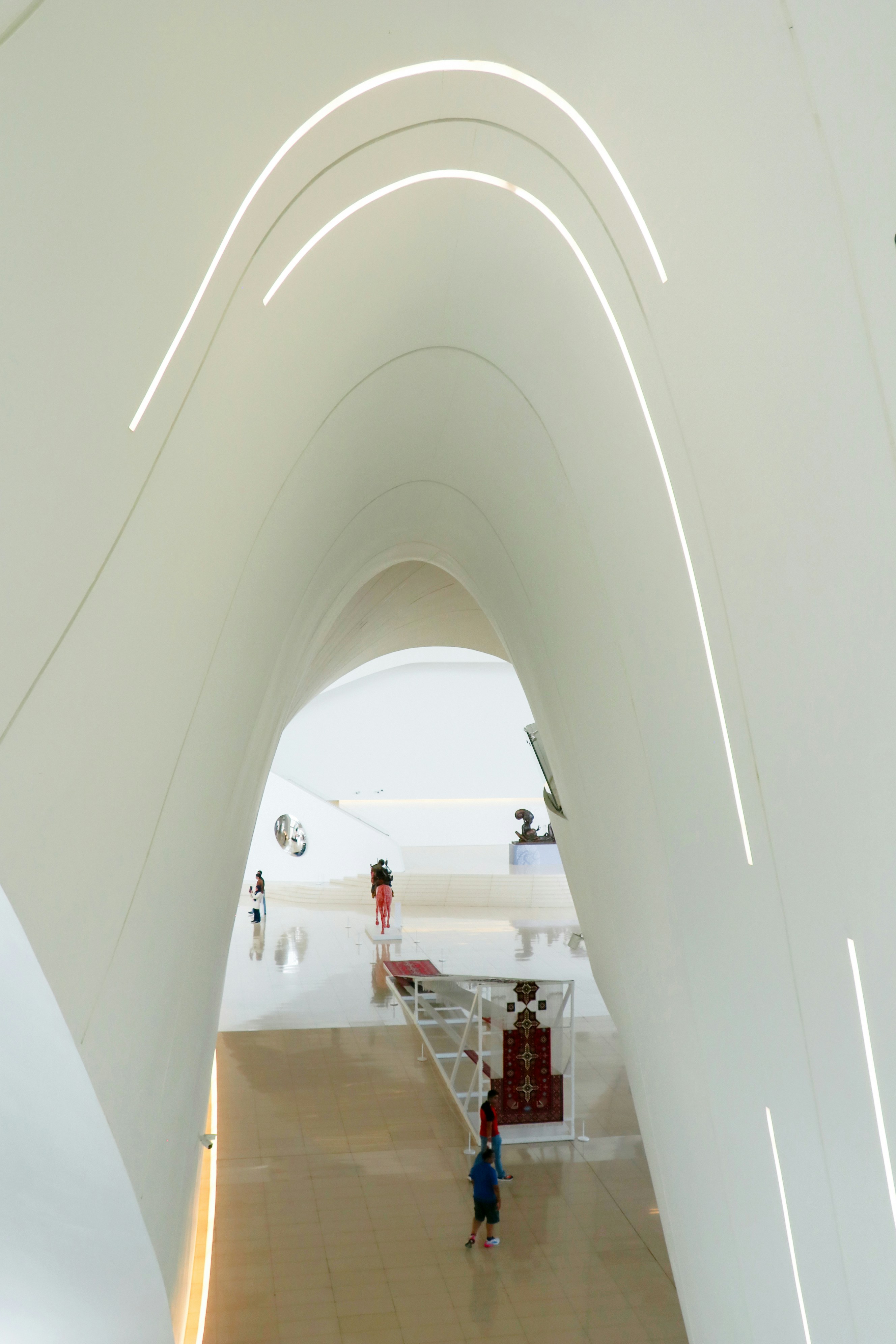 Modern white architecture with curved ceilings and lights.