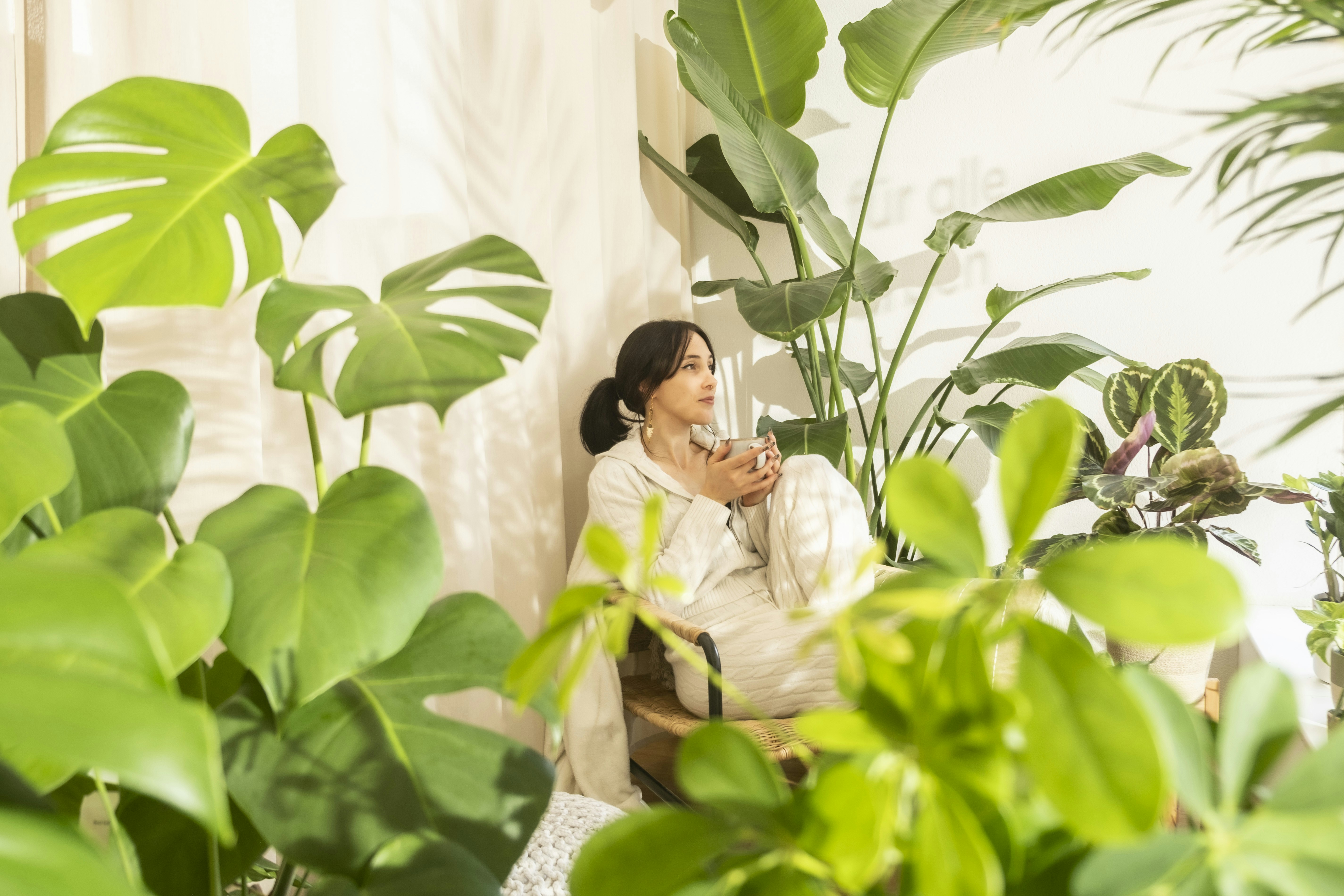Woman relaxing among lush green plants