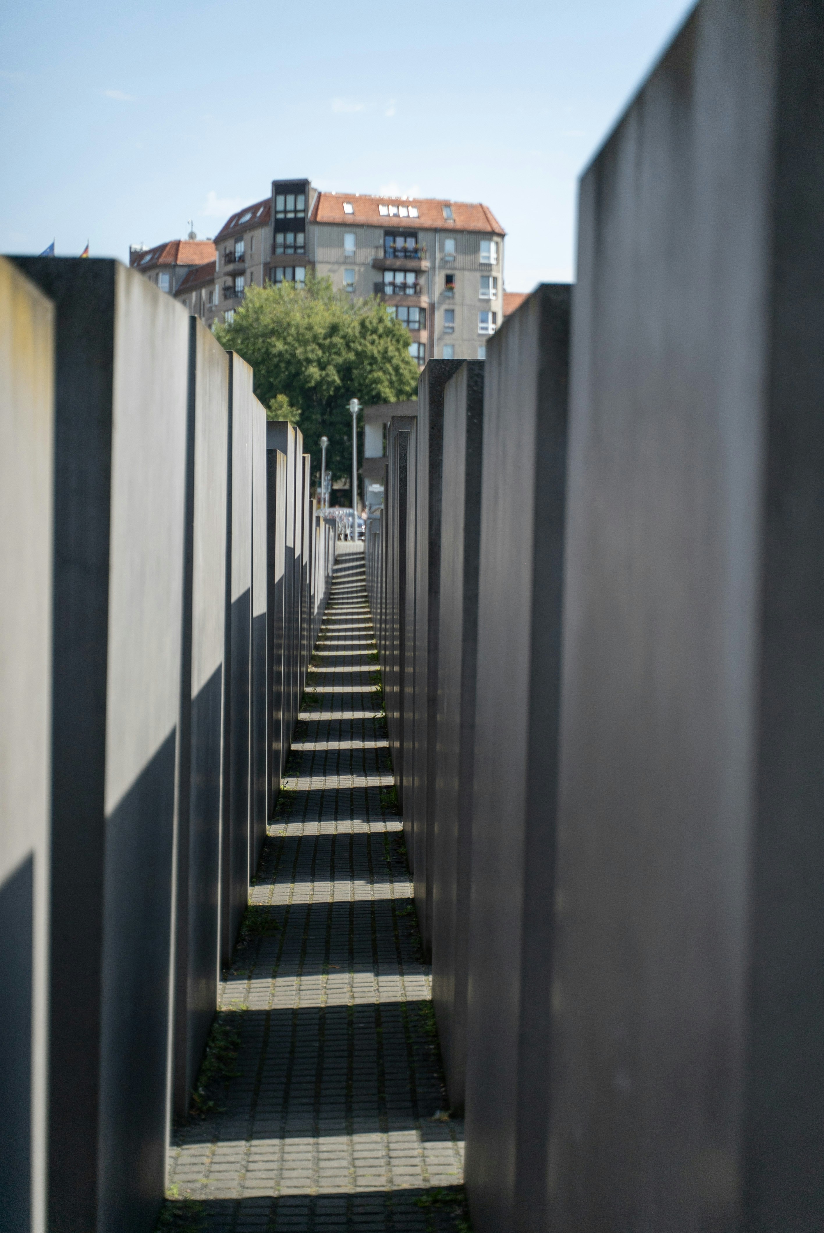 Tall concrete pillars create a pathway between buildings.