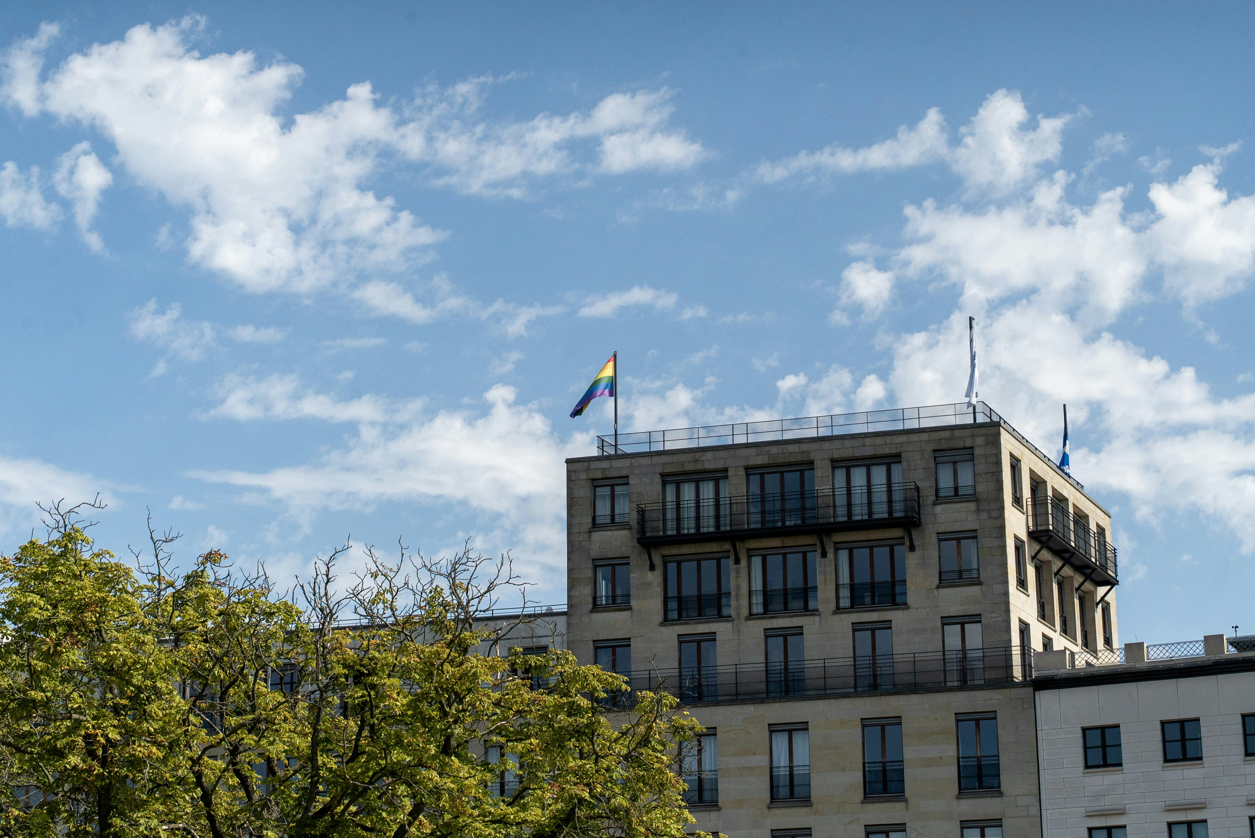 Building with trees under a cloudy blue sky
