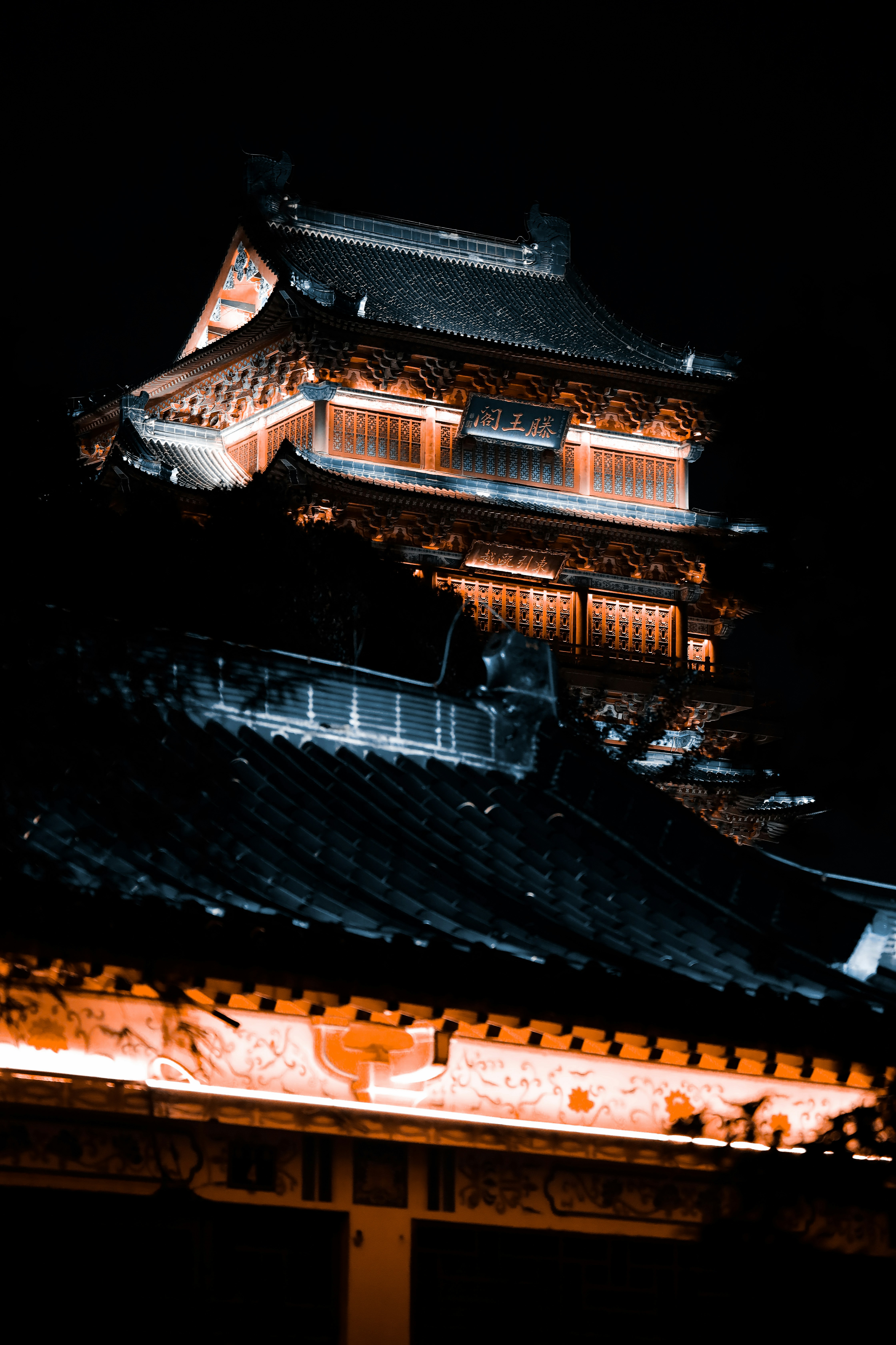 A serene night view of traditional Chinese architecture, glowing warmly under the night sky, showcasing the timeless elegance of ancient design. | Historic japanese castle illuminated at night