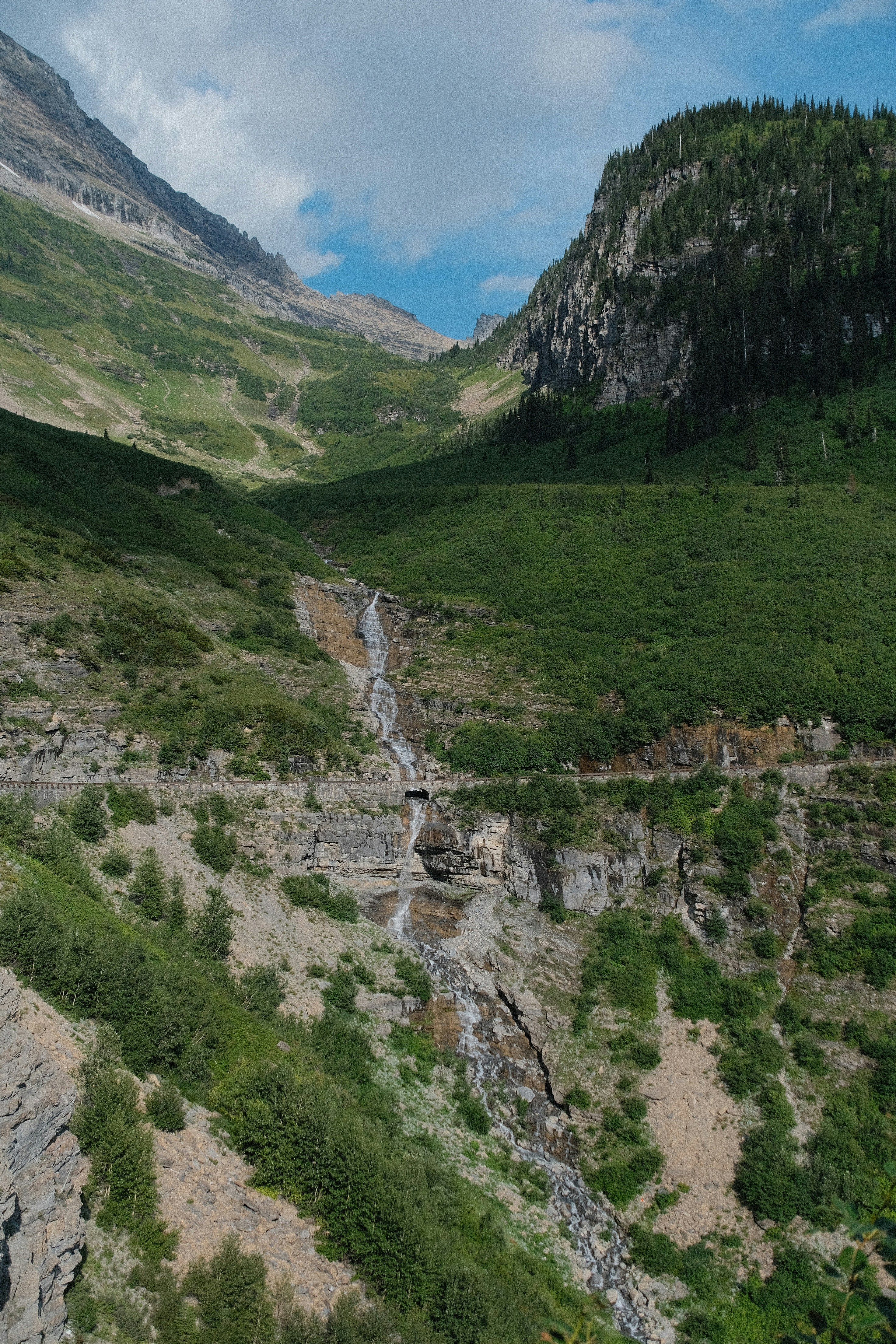 Mountain valley with a winding road and waterfall