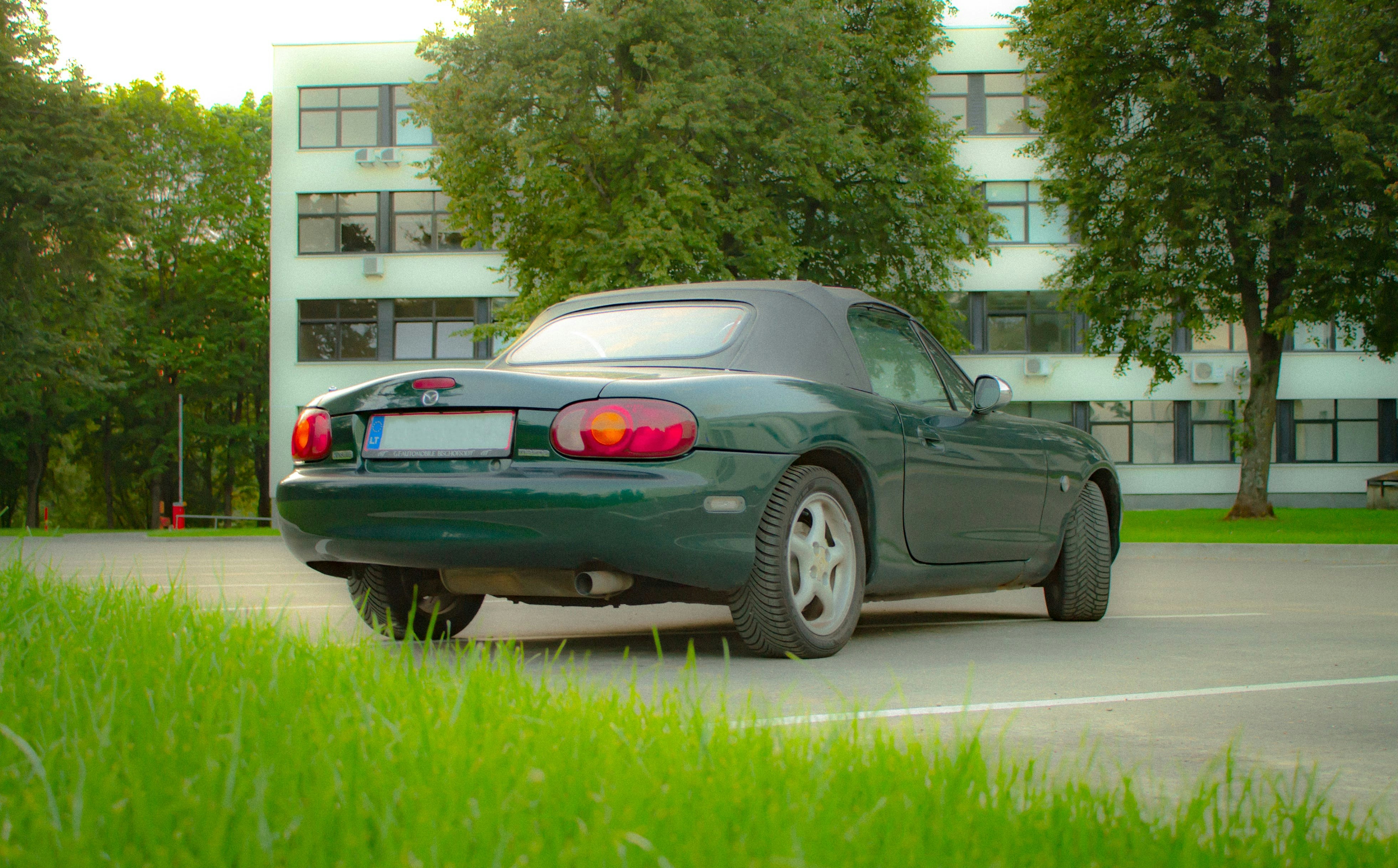 Mazda MX-5, rear 3/4 | shot by @taupavyks on Instagram | Green convertible car parked near a building