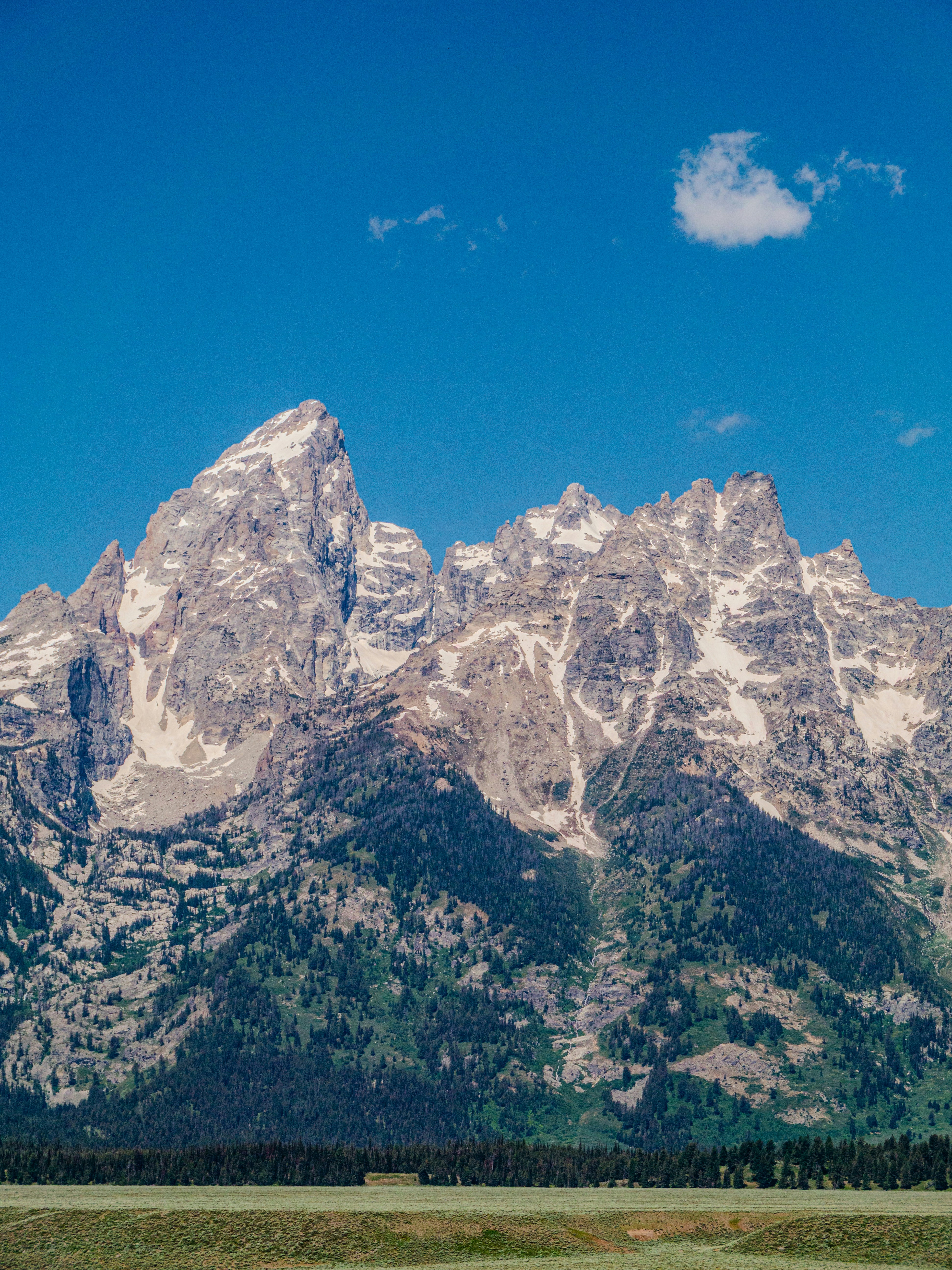 The Teton range in Wyoming | Snow-capped mountains under a clear blue sky.
