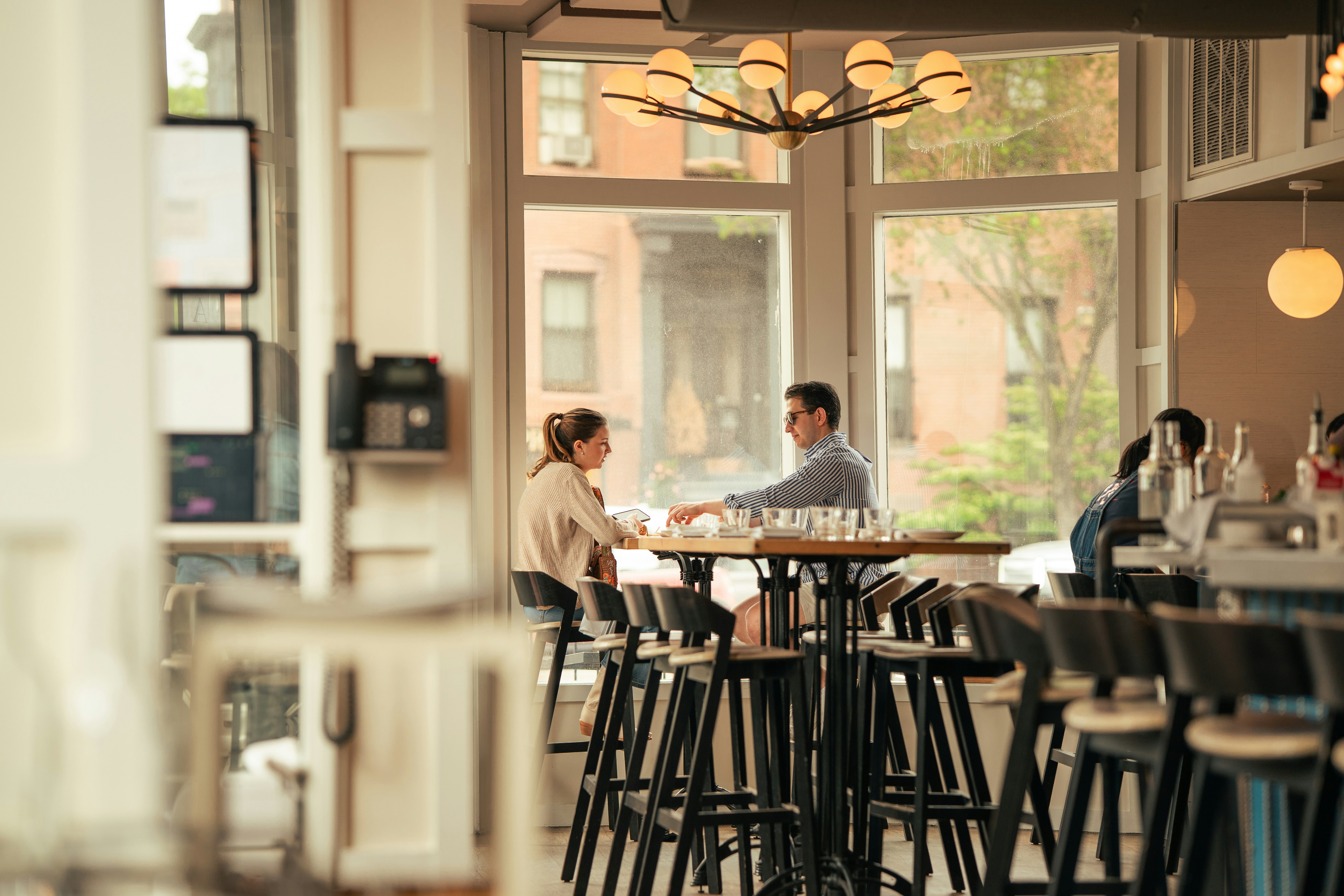 Lunch Date | Couple talking at a table in a modern cafe.