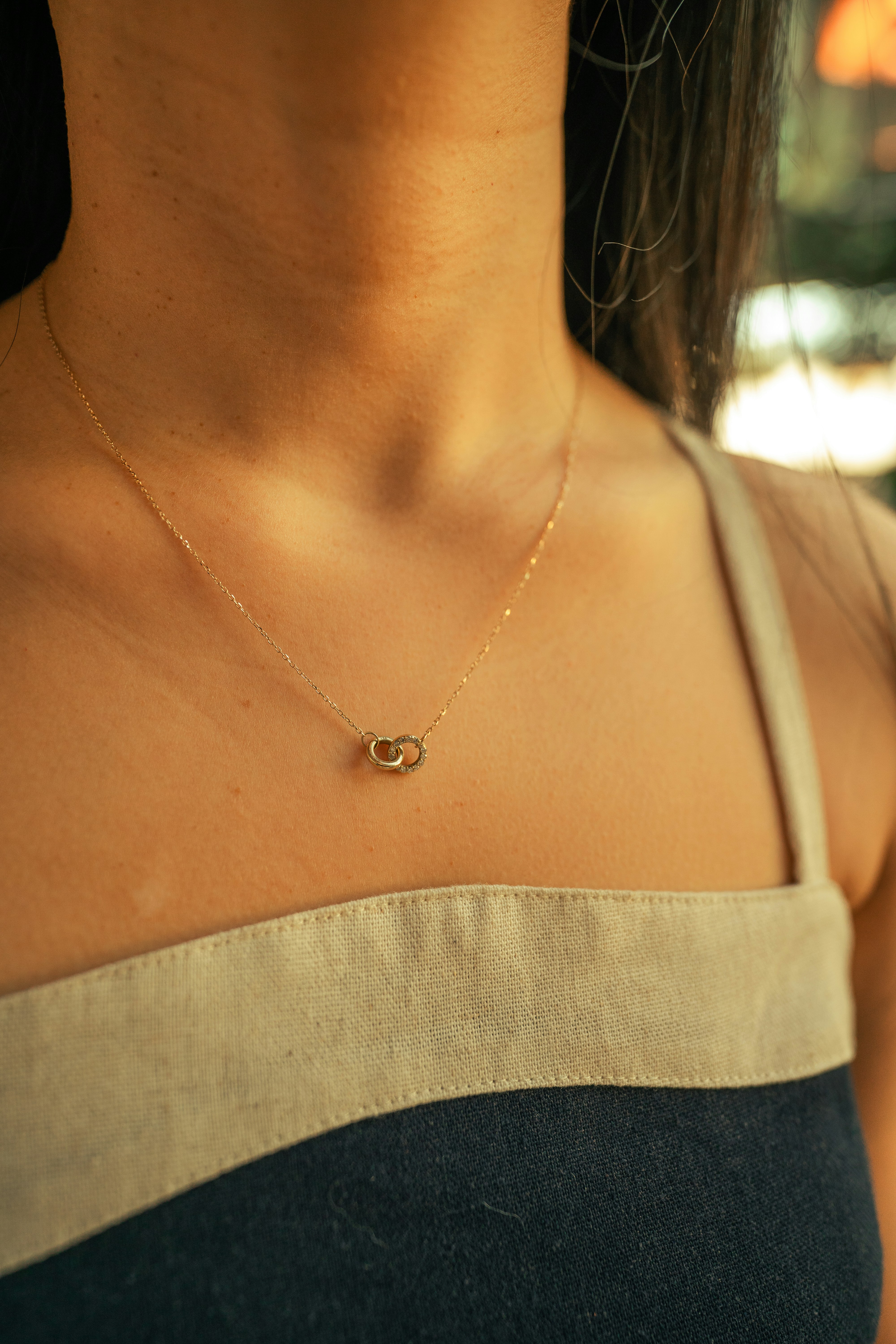 Woman wearing a gold necklace with interlocking rings photo – Free ...