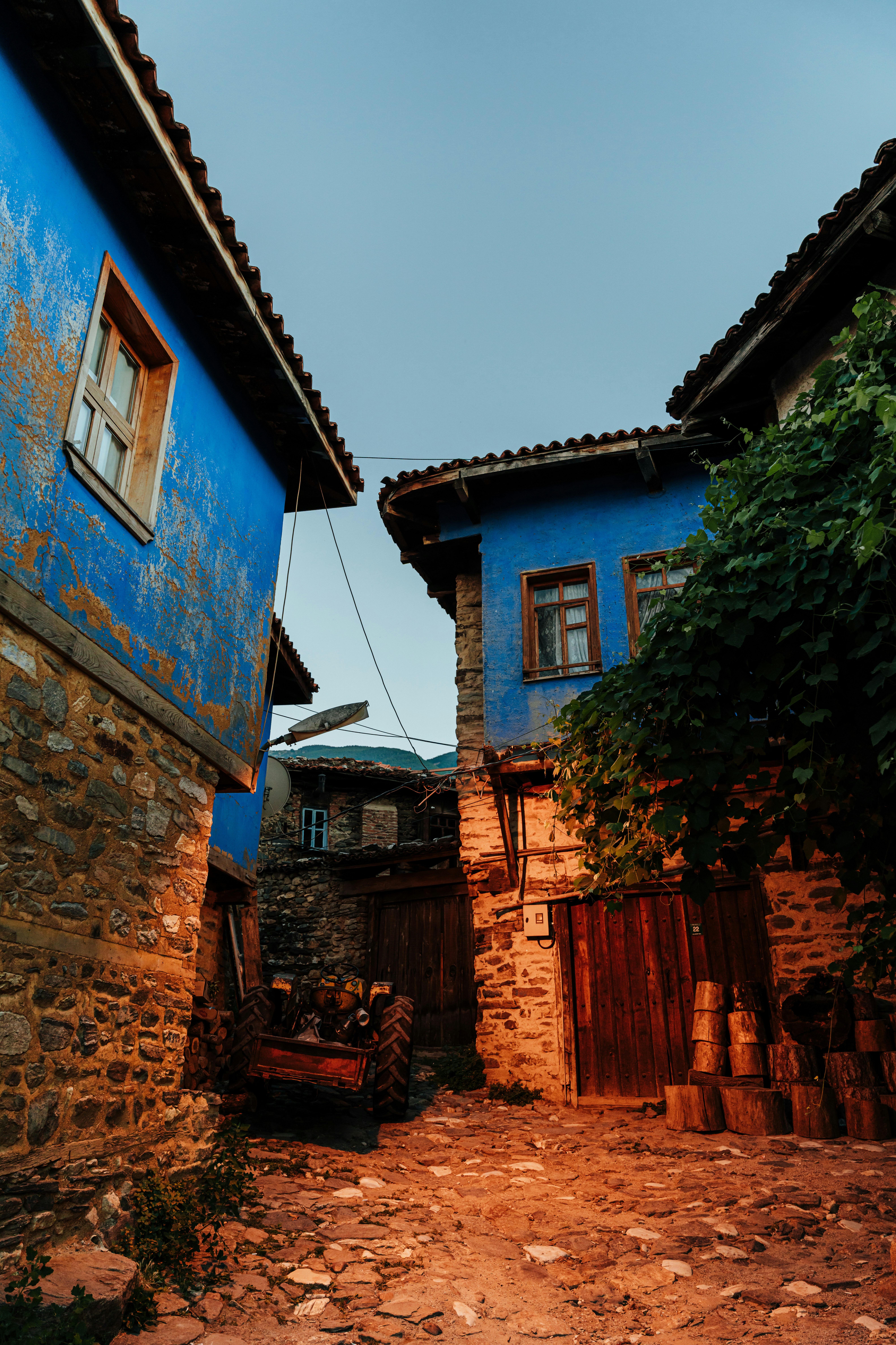 Cobblestone alley between blue houses at dusk