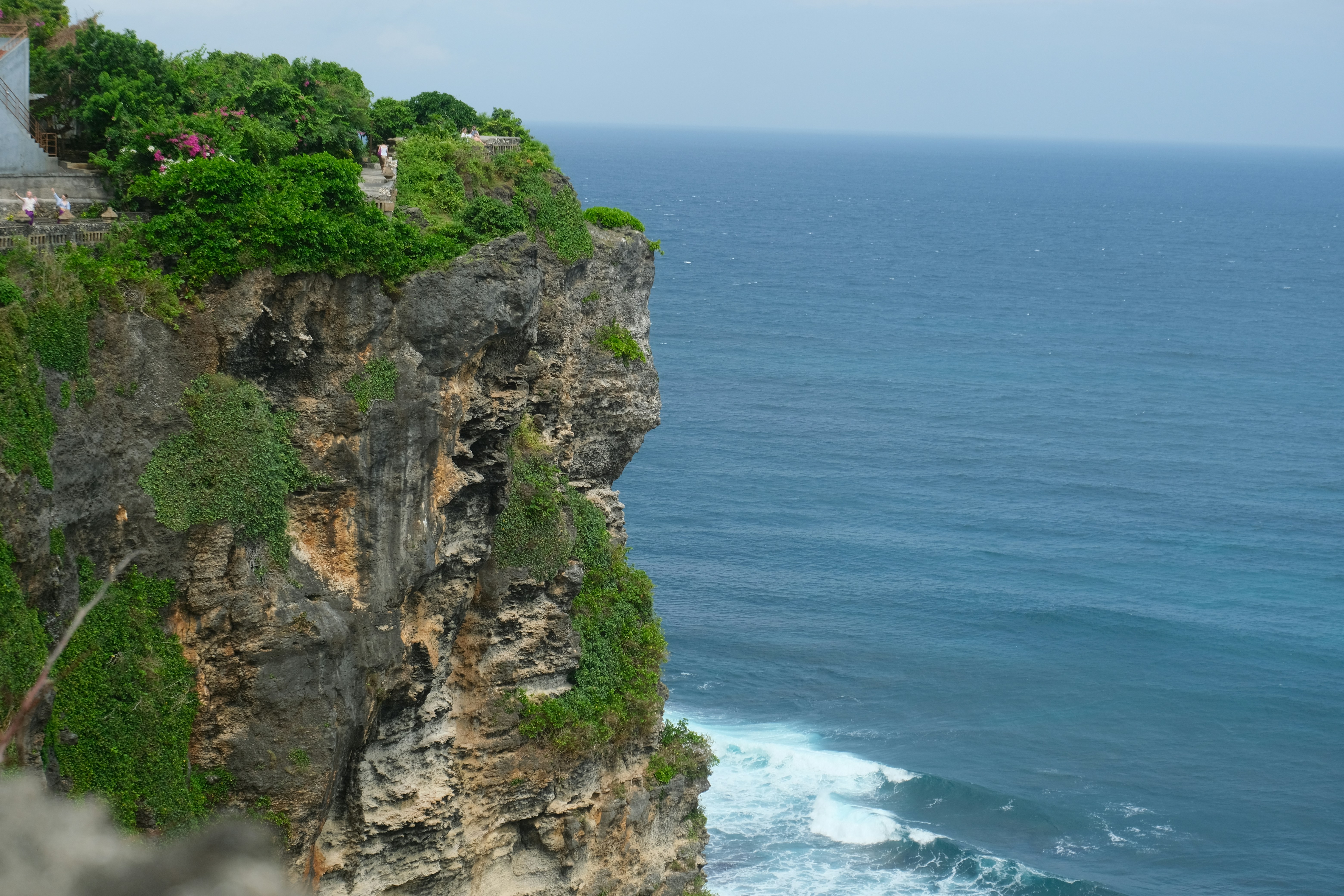 Lush green cliff overlooking a blue ocean