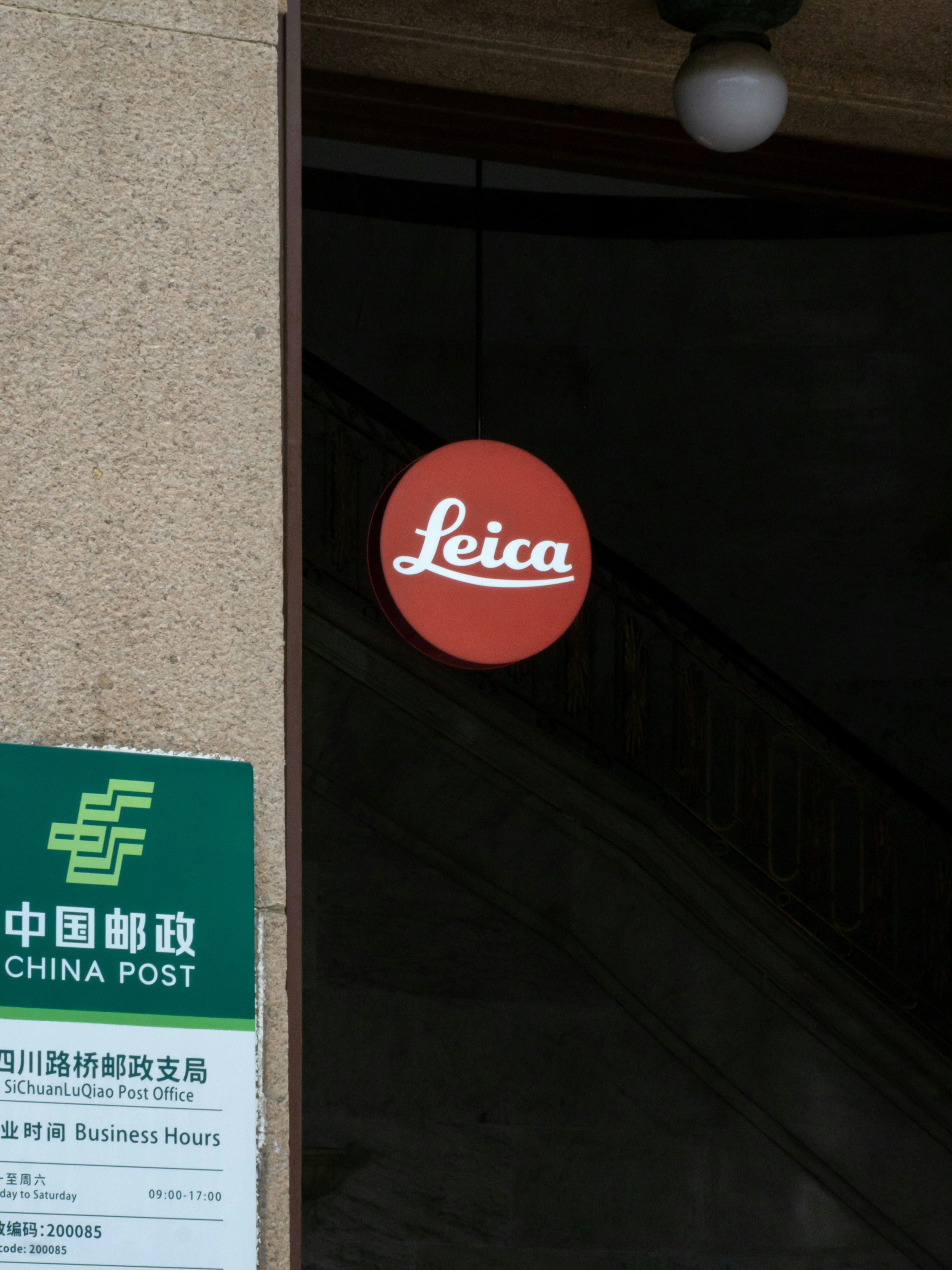 OLYMPUS DIGITAL CAMERA | Red leica logo above china post sign