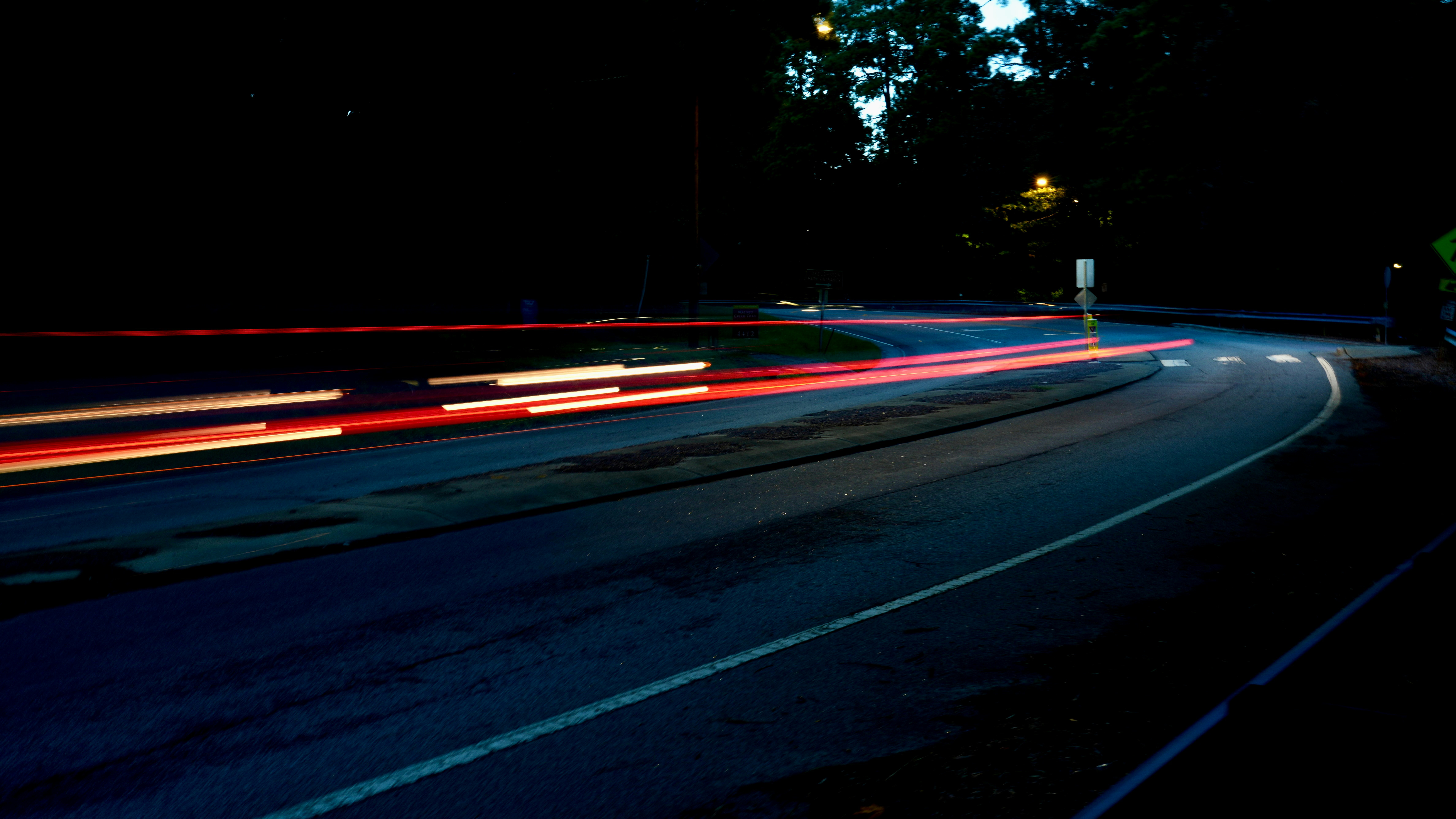 Light trails on a dark, winding road at night