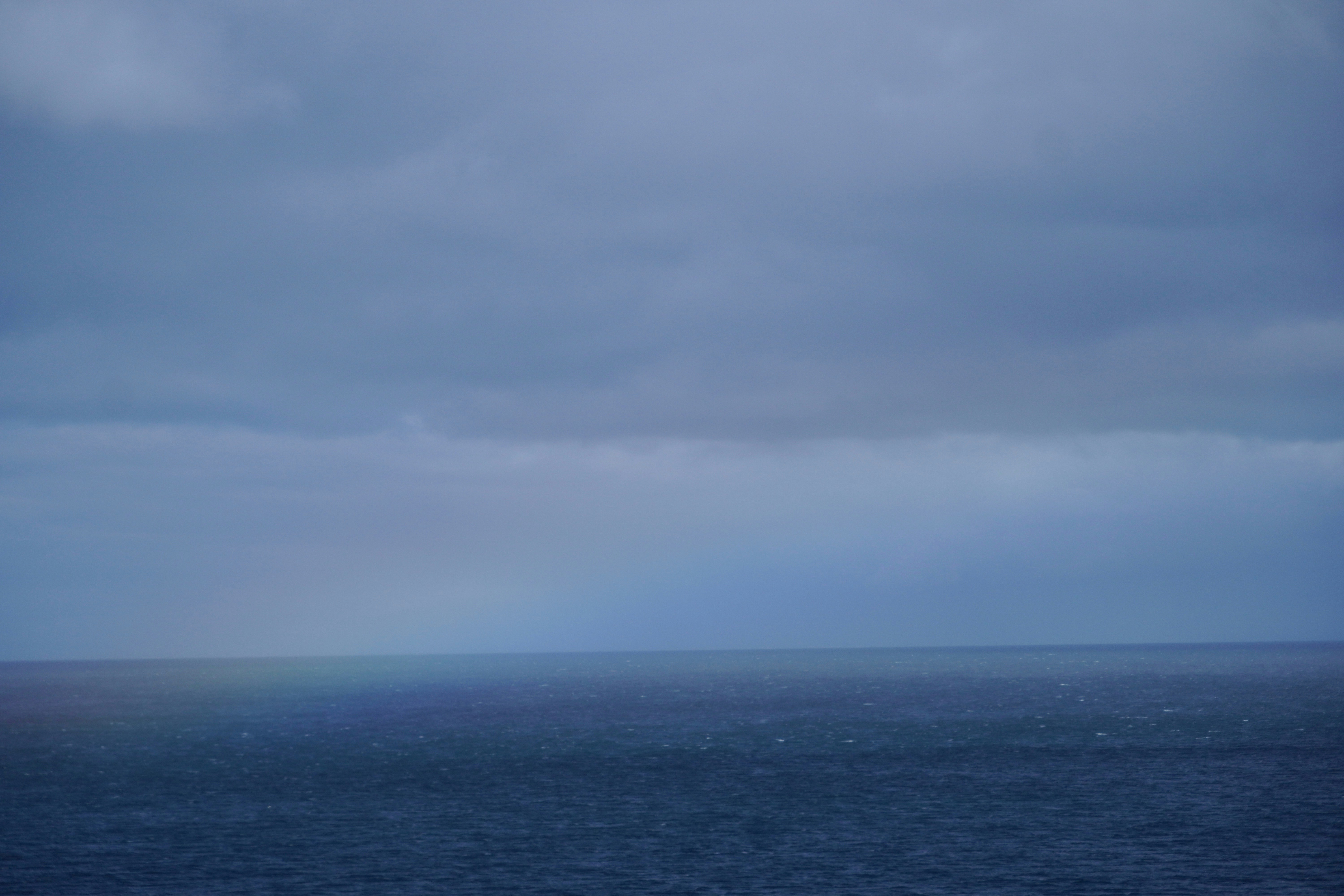 Dark clouds over a calm ocean horizon