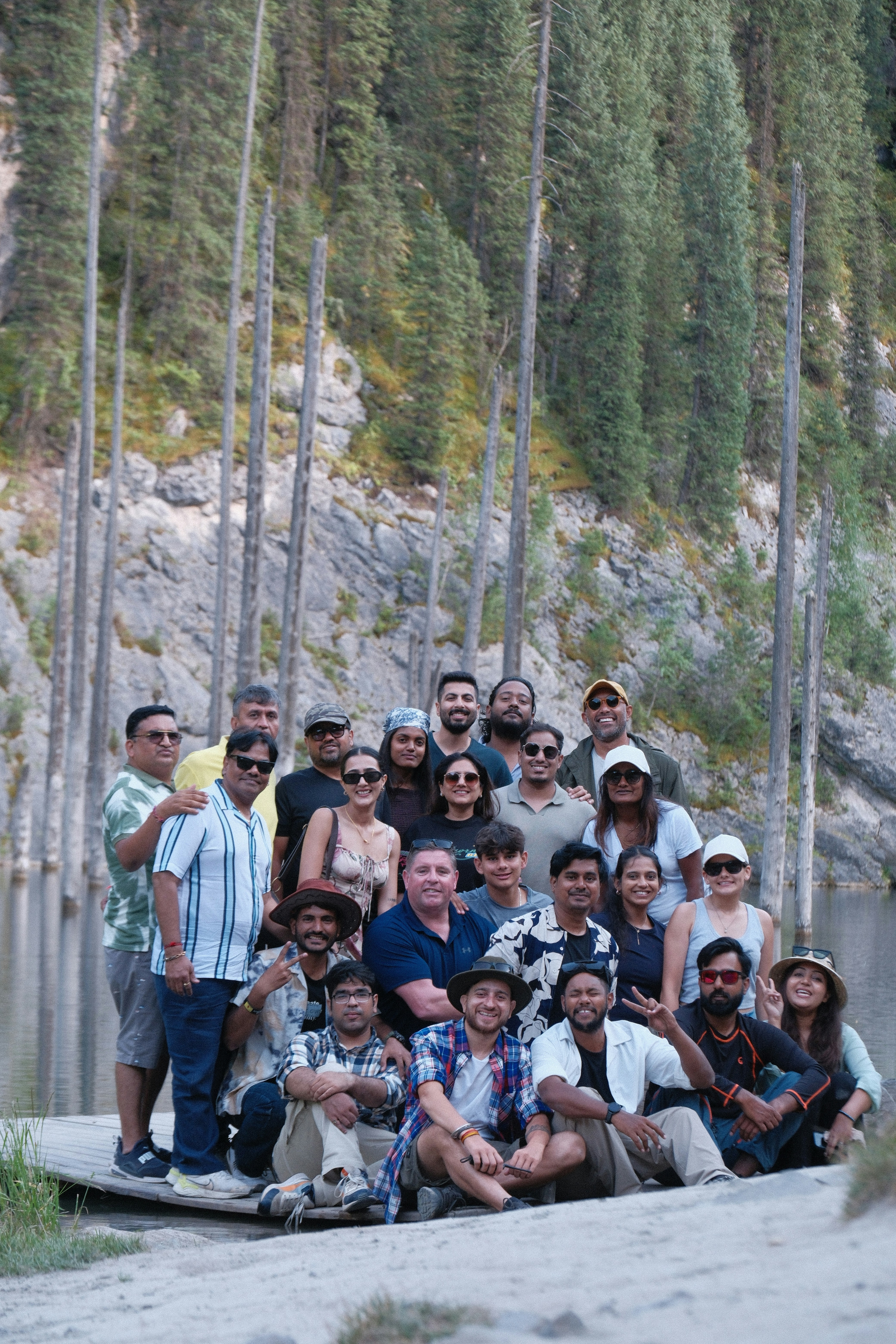 Group of people posing for a photo near a lake.