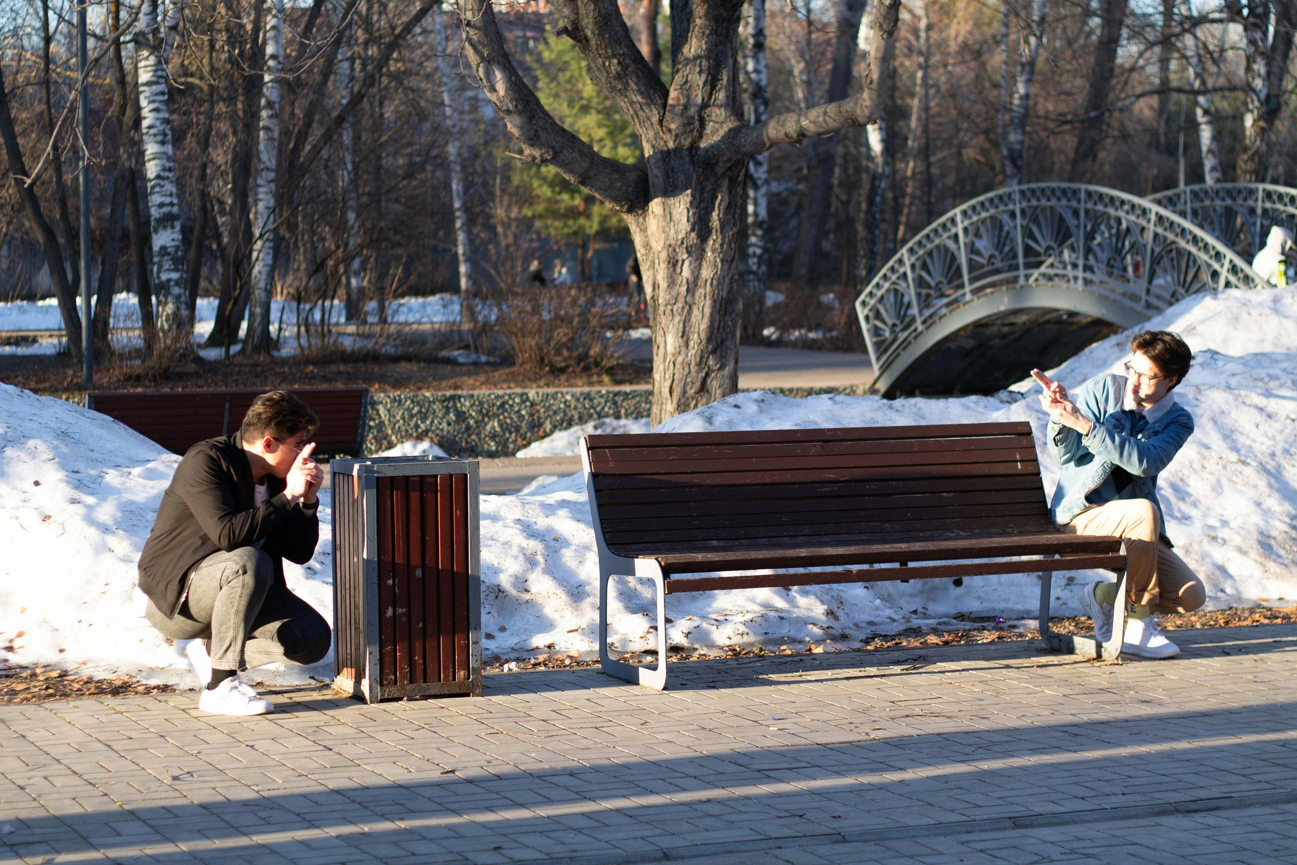 Two people taking pictures in a park