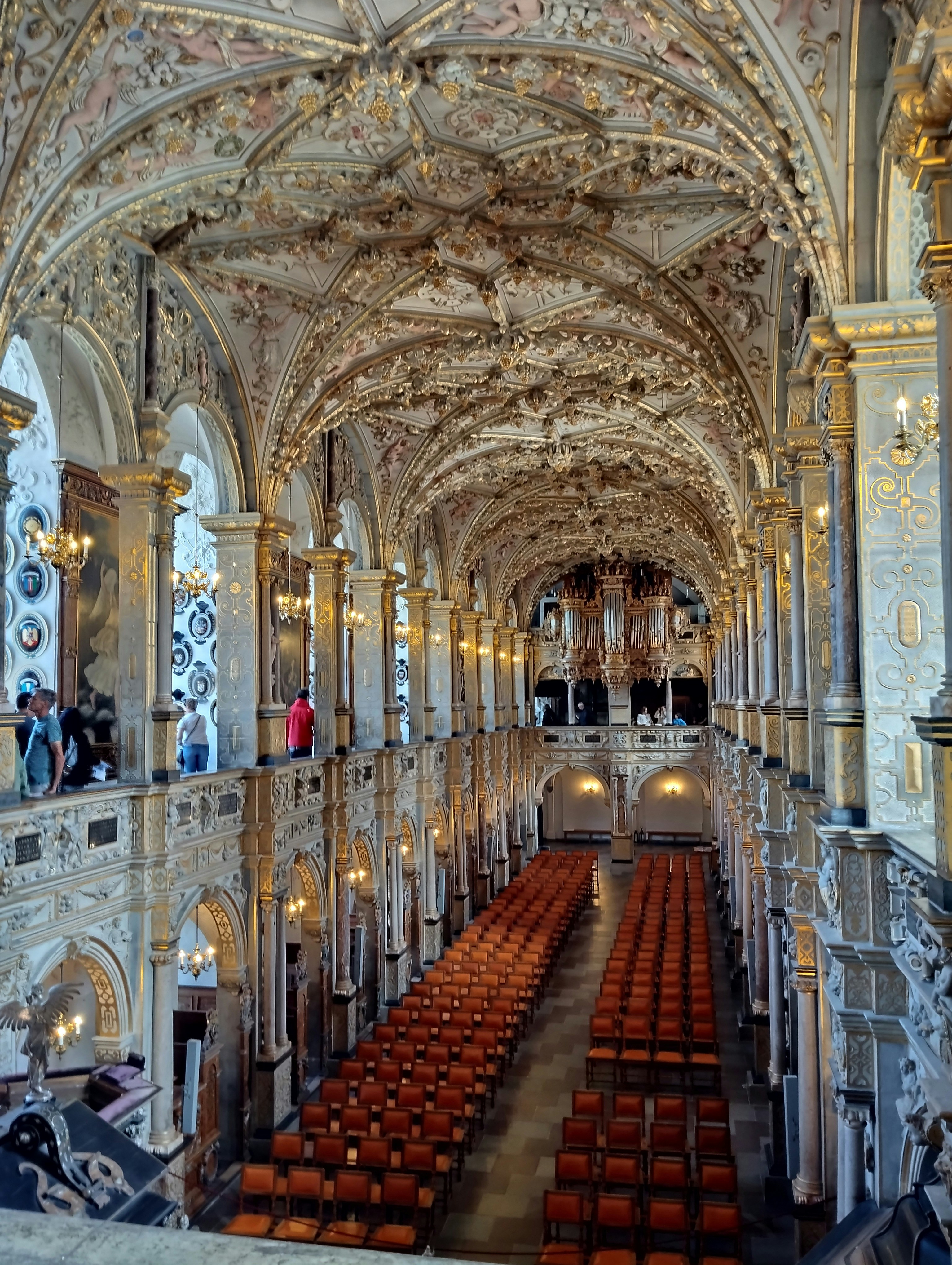 Ornate church interior with rows of orange seats.