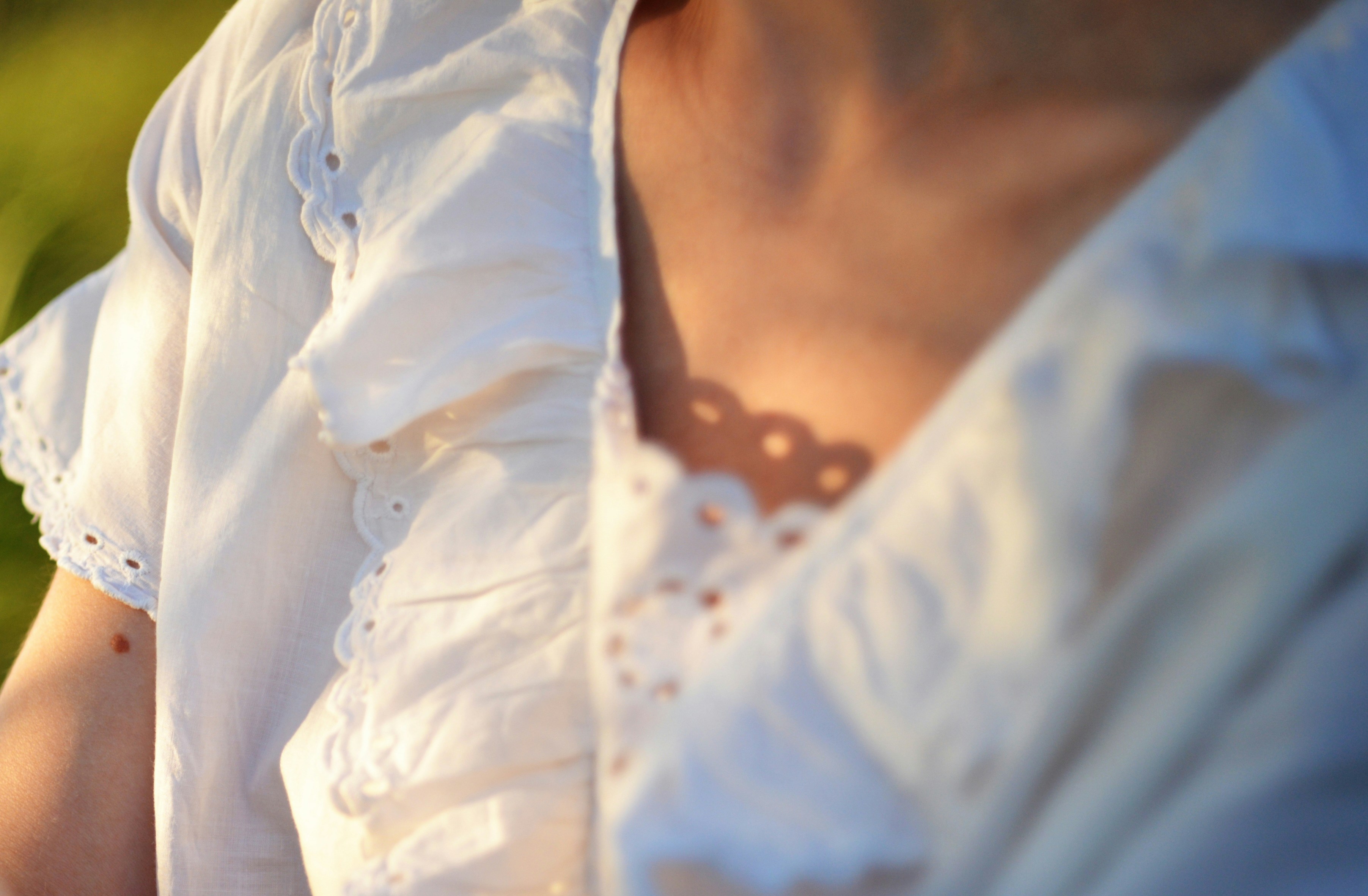 Woman in white dress with sunlight on her shoulder