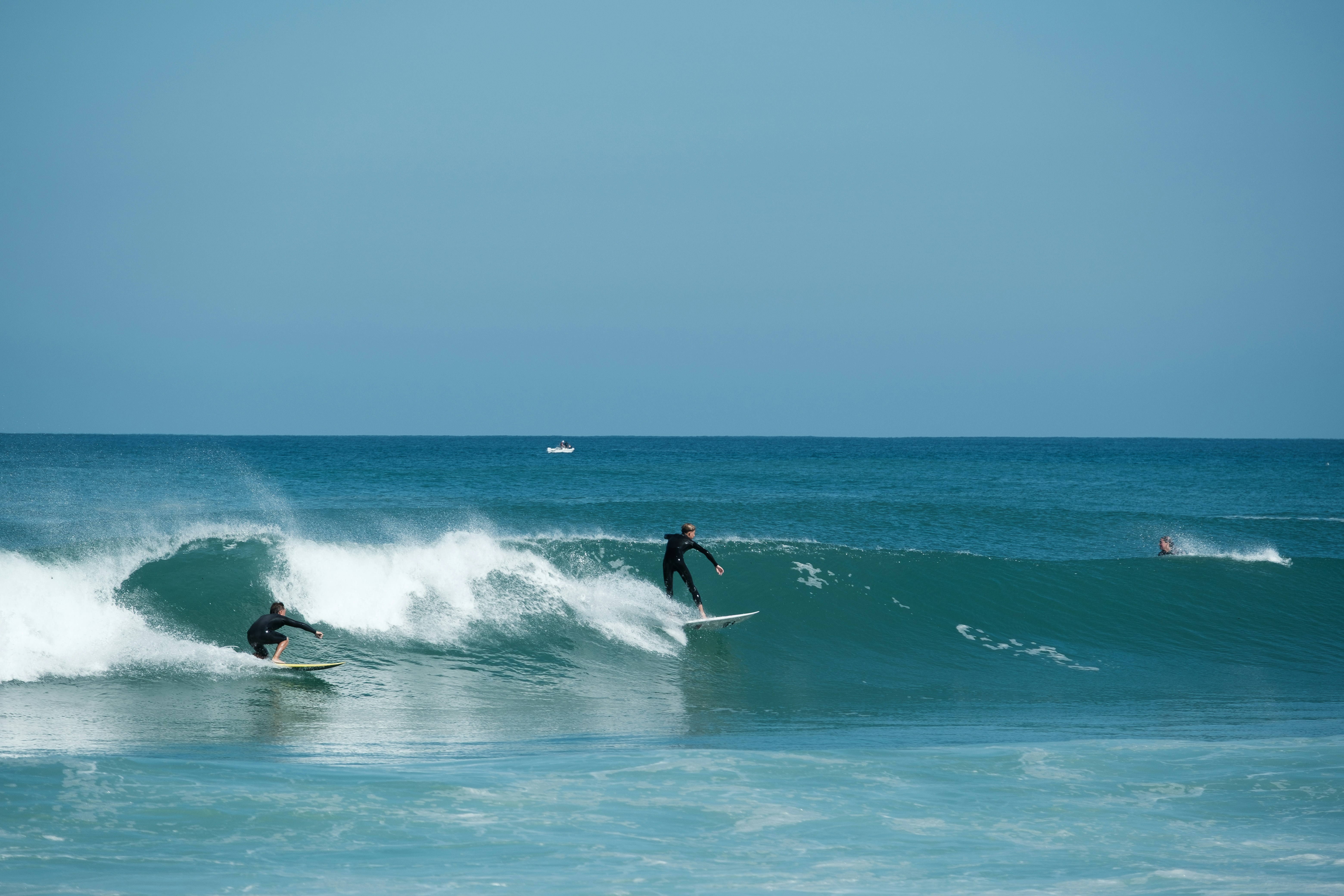 Two surfers riding waves on a sunny day