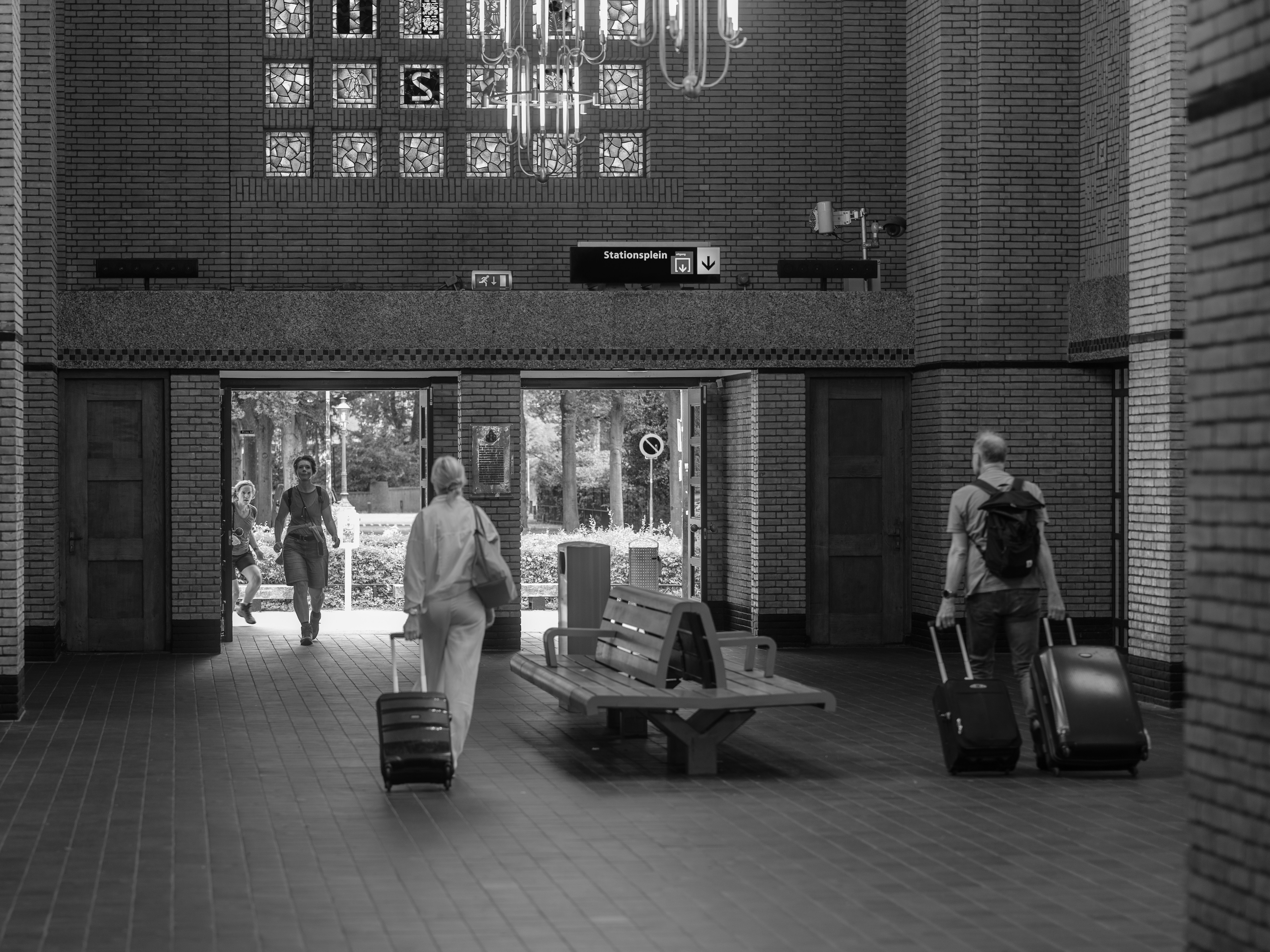 Luggage in Transit: Quiet Return Through the Brick Hall