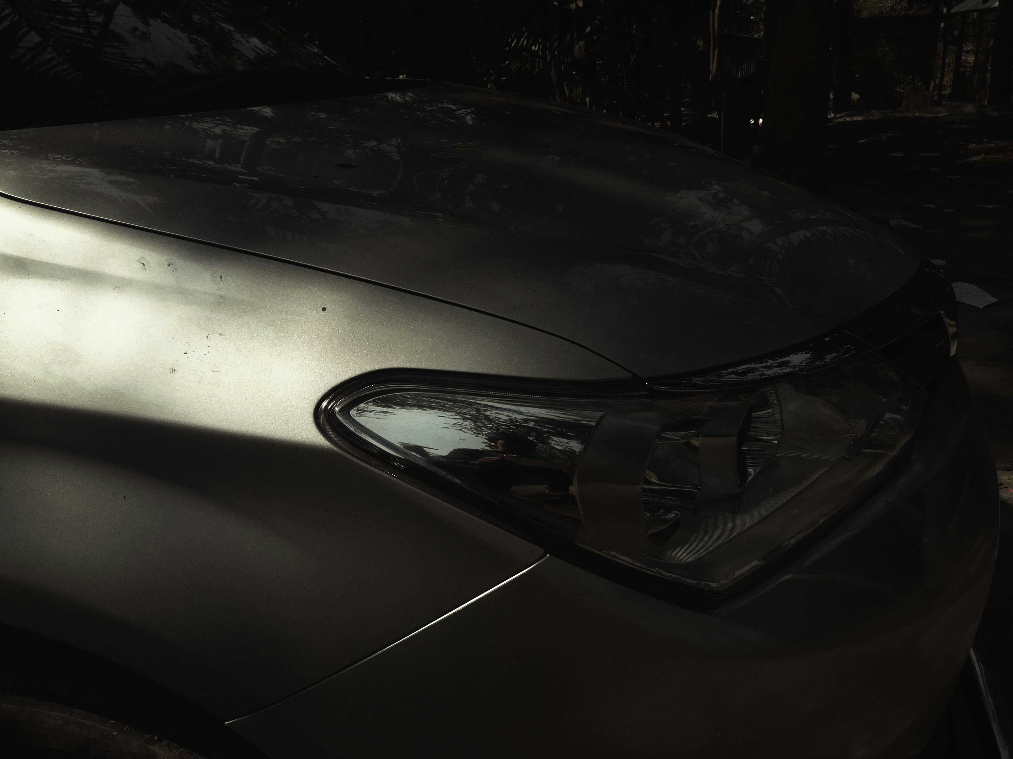 Close-up of a car headlight and hood