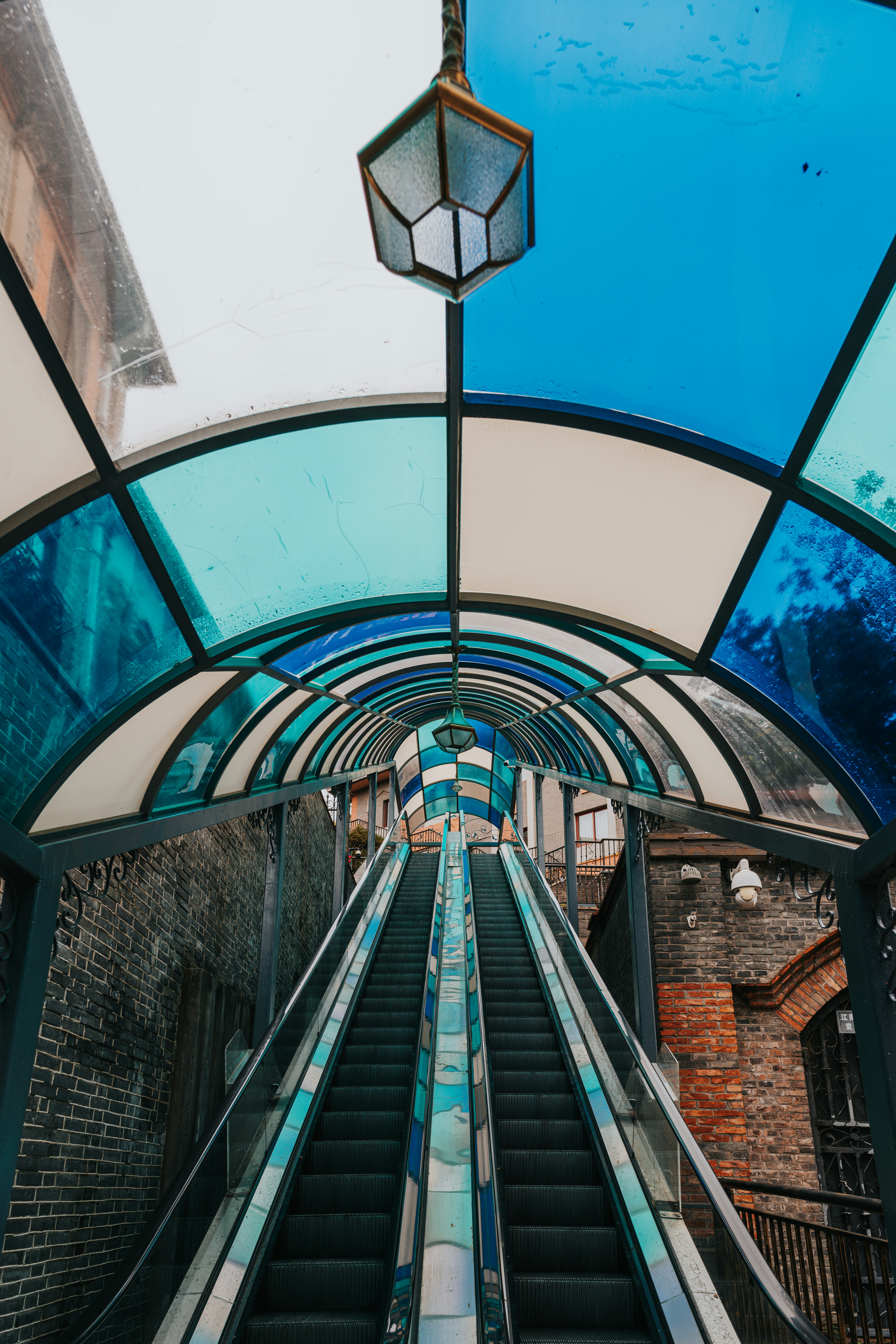 Escalator under a colorful glass ceiling photo – Free Image on Unsplash