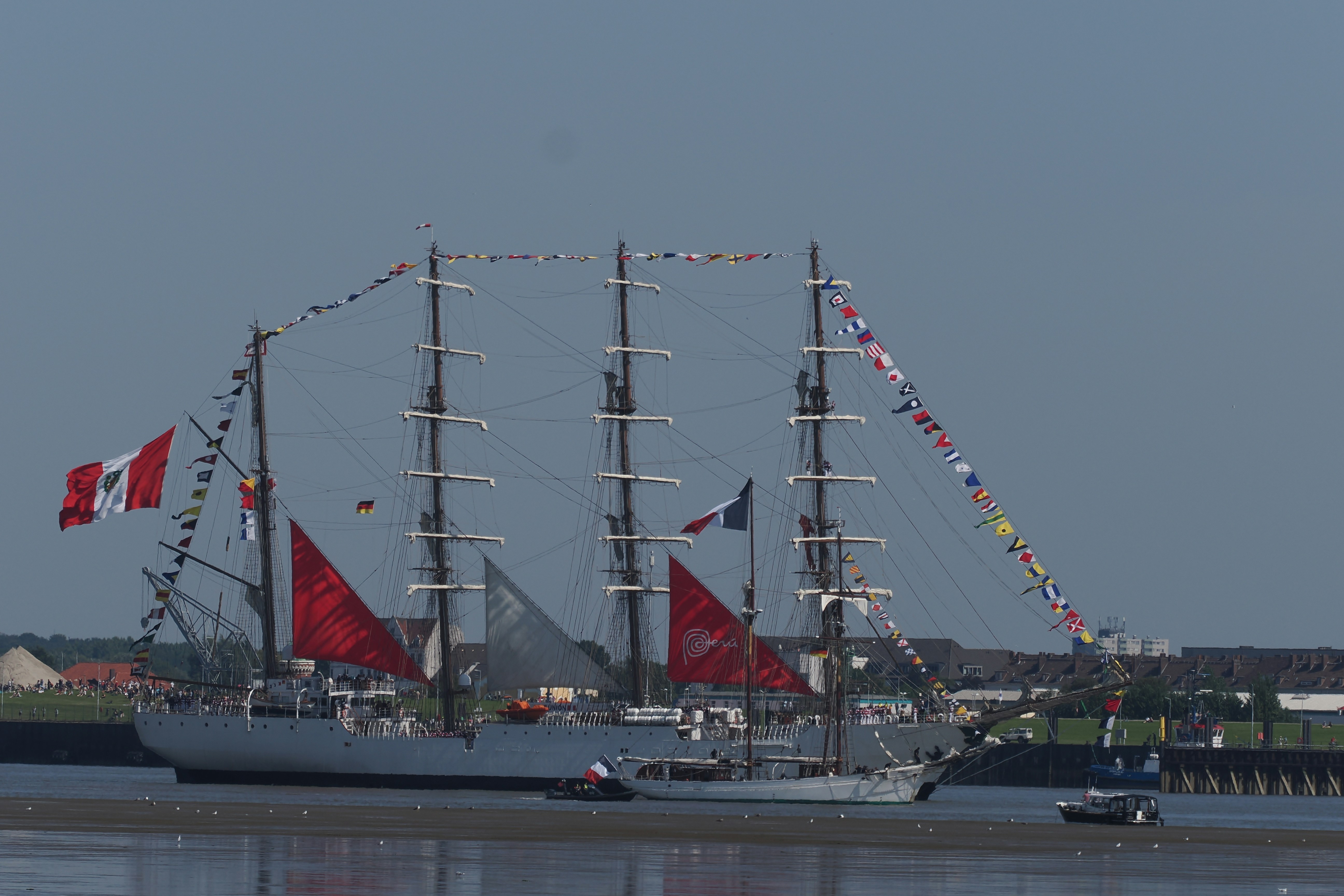Eindrücke von der SAIL 25 in Bremerhaven | Tall ship with red sails and flags sails on water