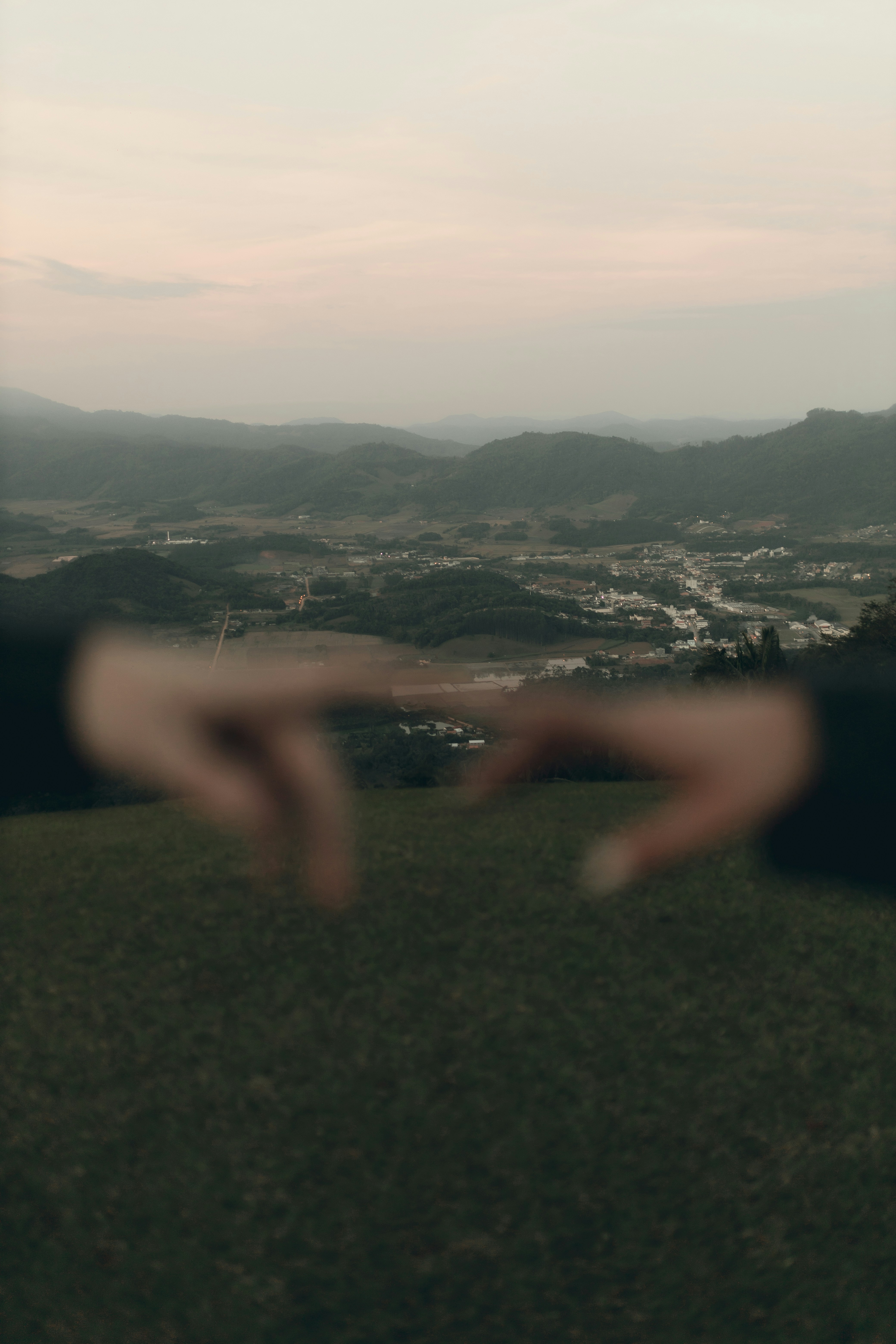 Hands forming heart shape over distant landscape