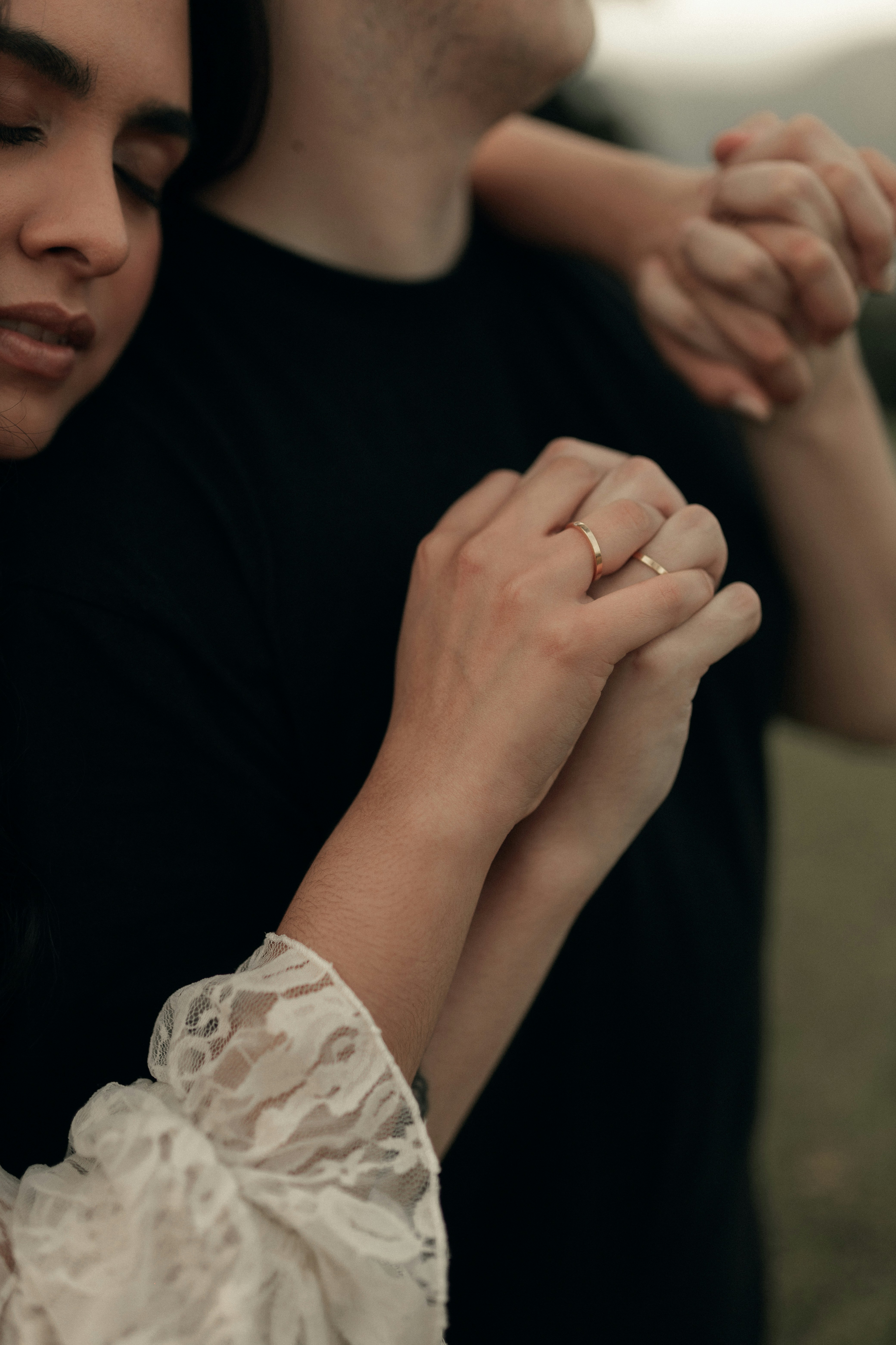 Couple holding hands with wedding rings