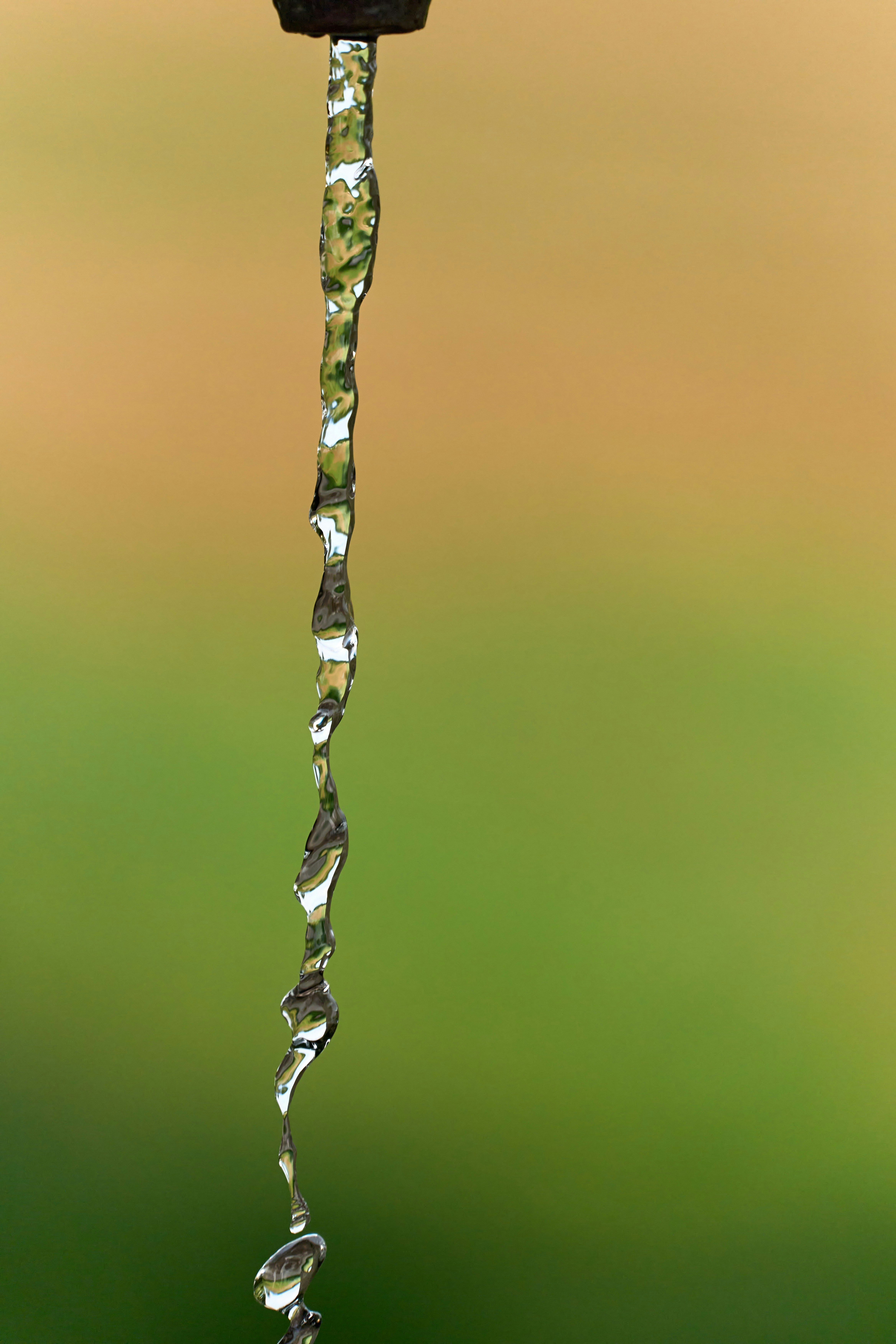 Water stream falling against blurred background