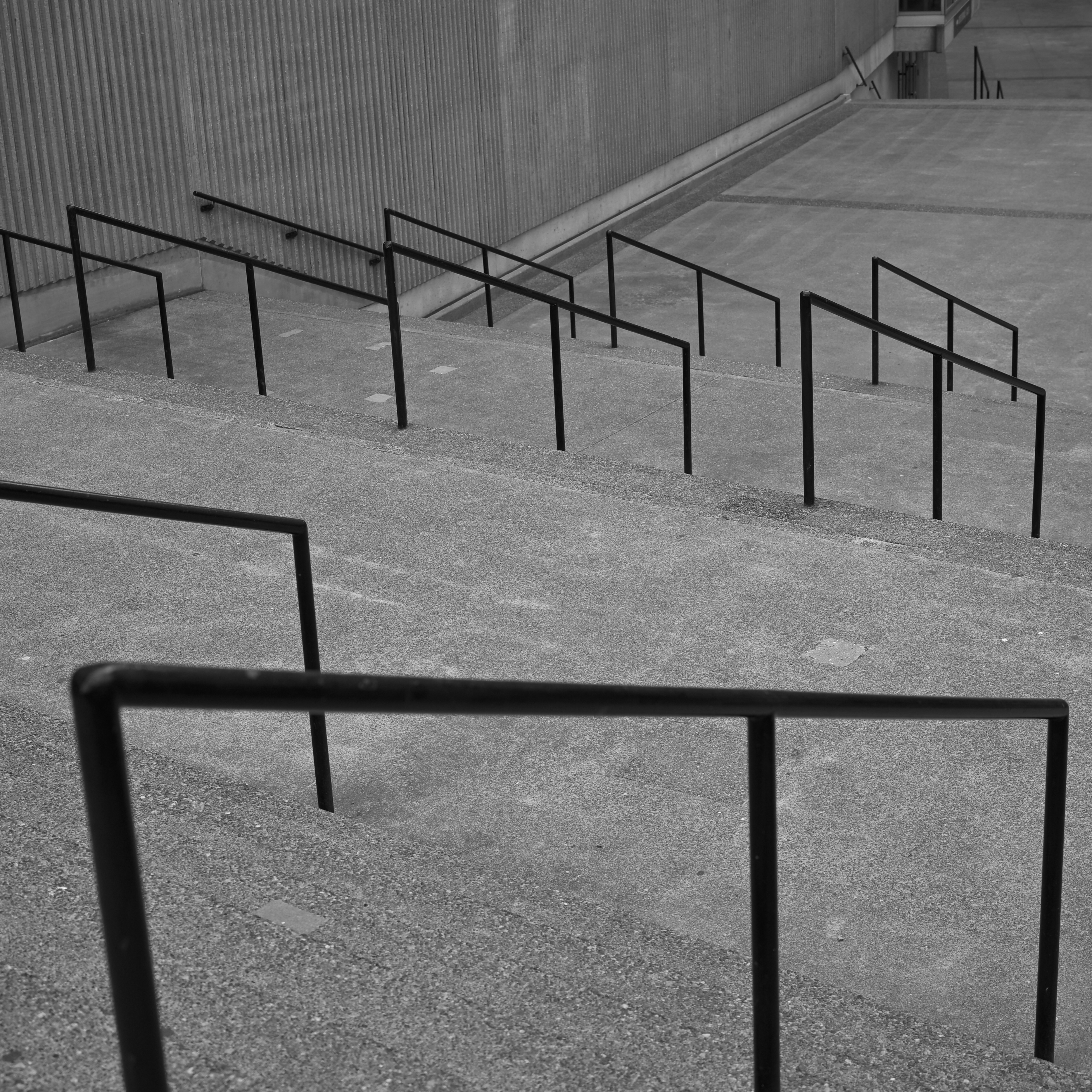 Black metal handrails on outdoor concrete stairs