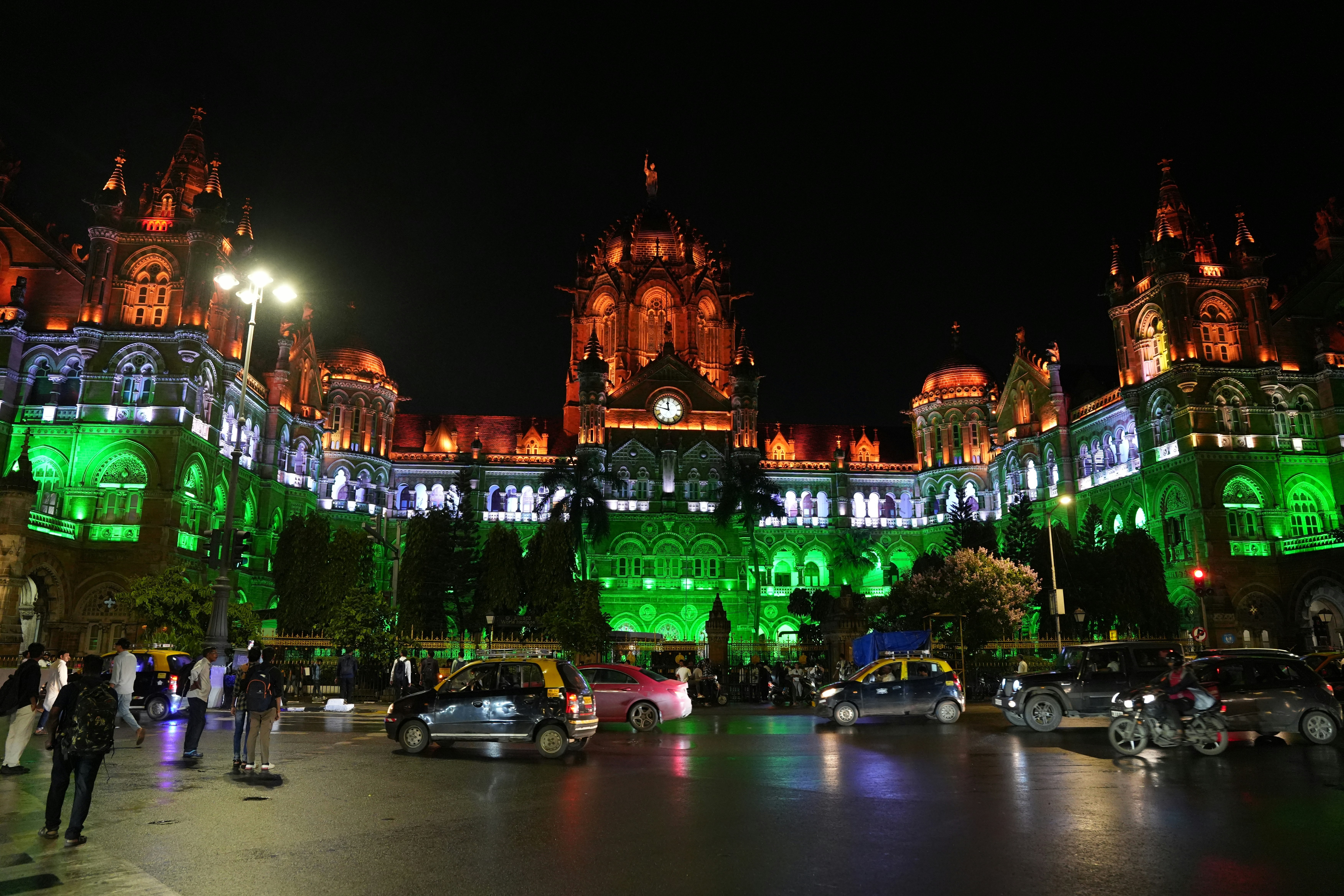 Historic building illuminated with green and orange lights at night