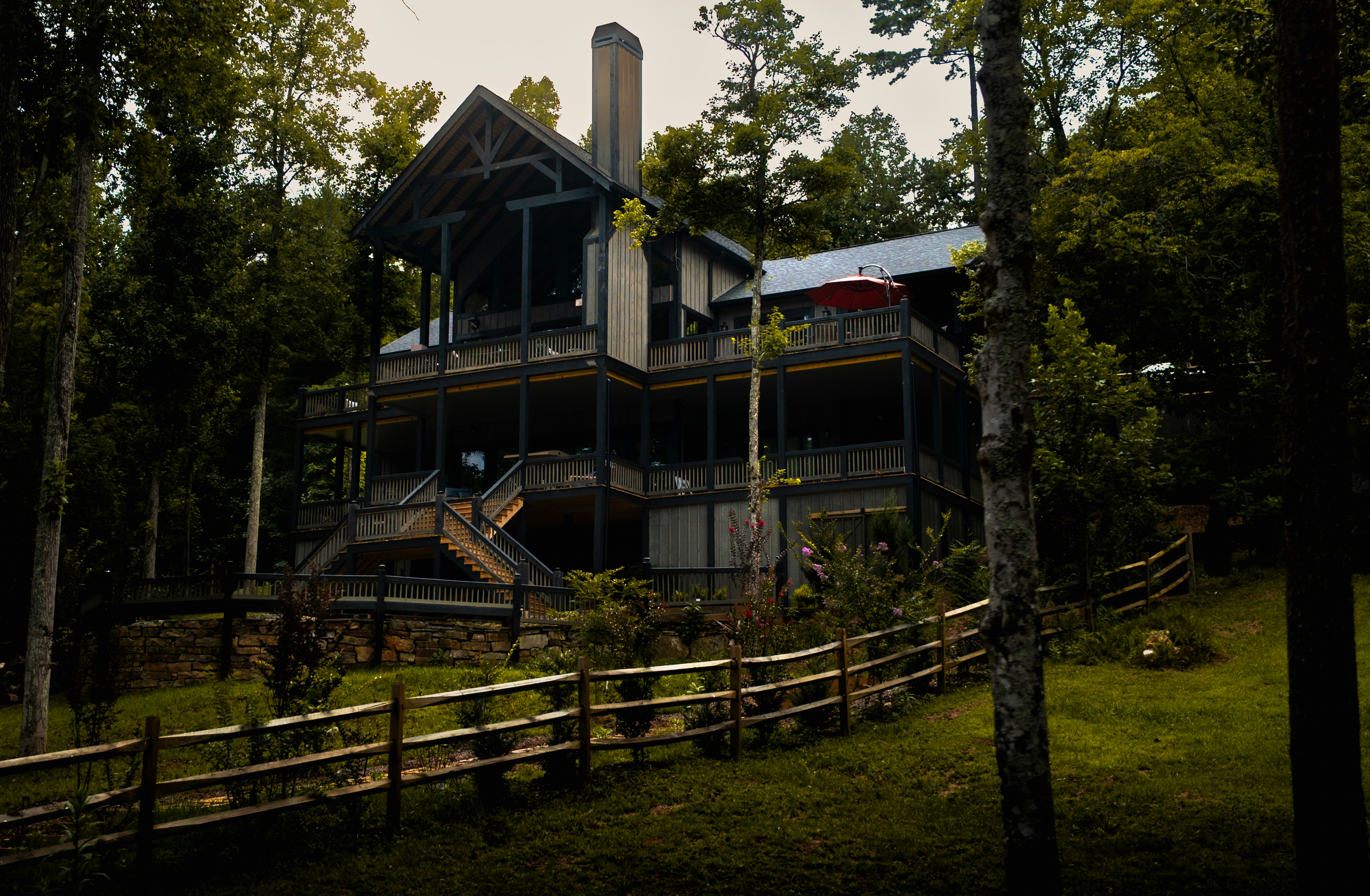 Scenery around the Blue Ridge Scenic Railway in Georgia. | Rustic house nestled among trees with wooden fence