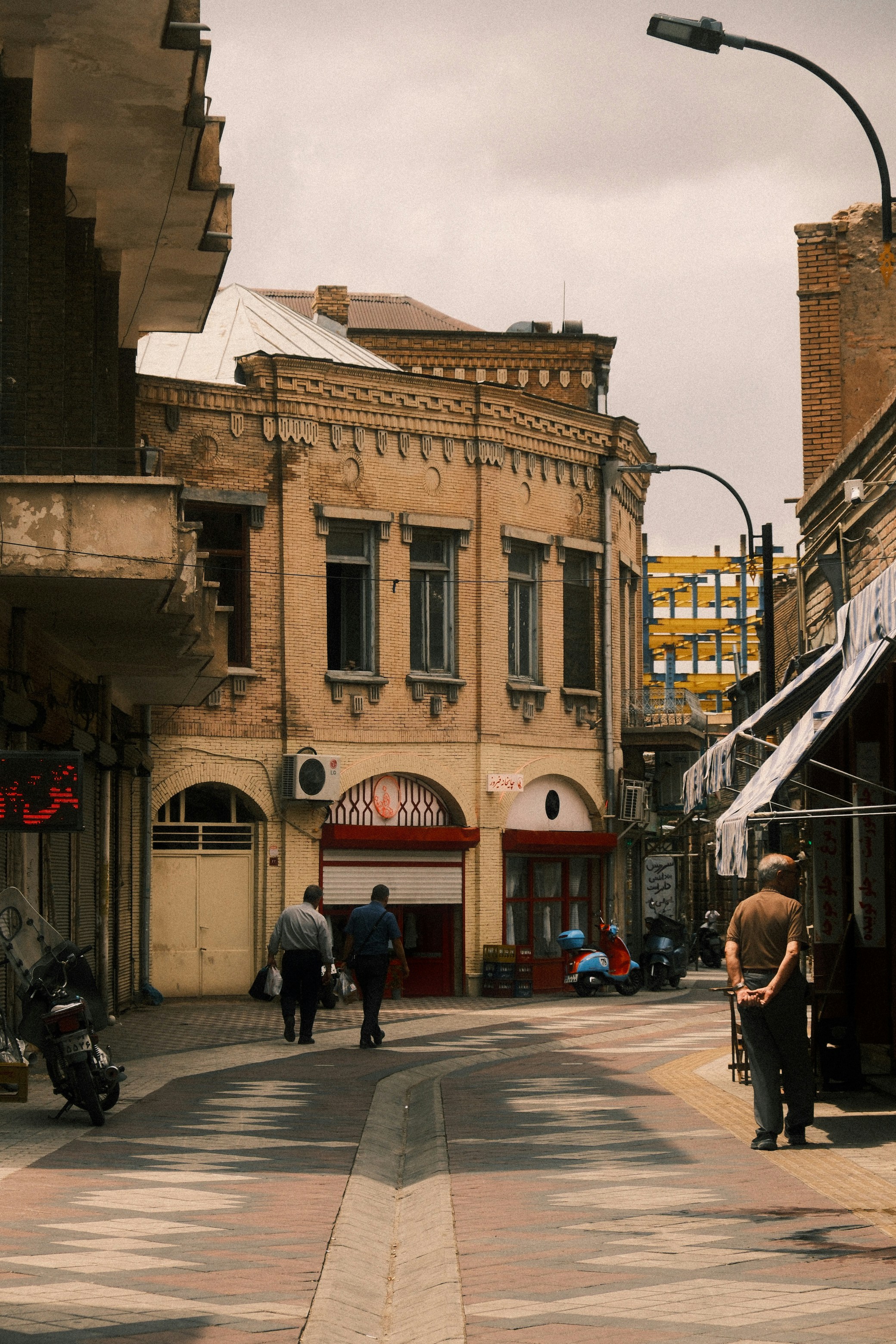 Brick Street Echoes: Quiet Crossing Under Arched Storefronts