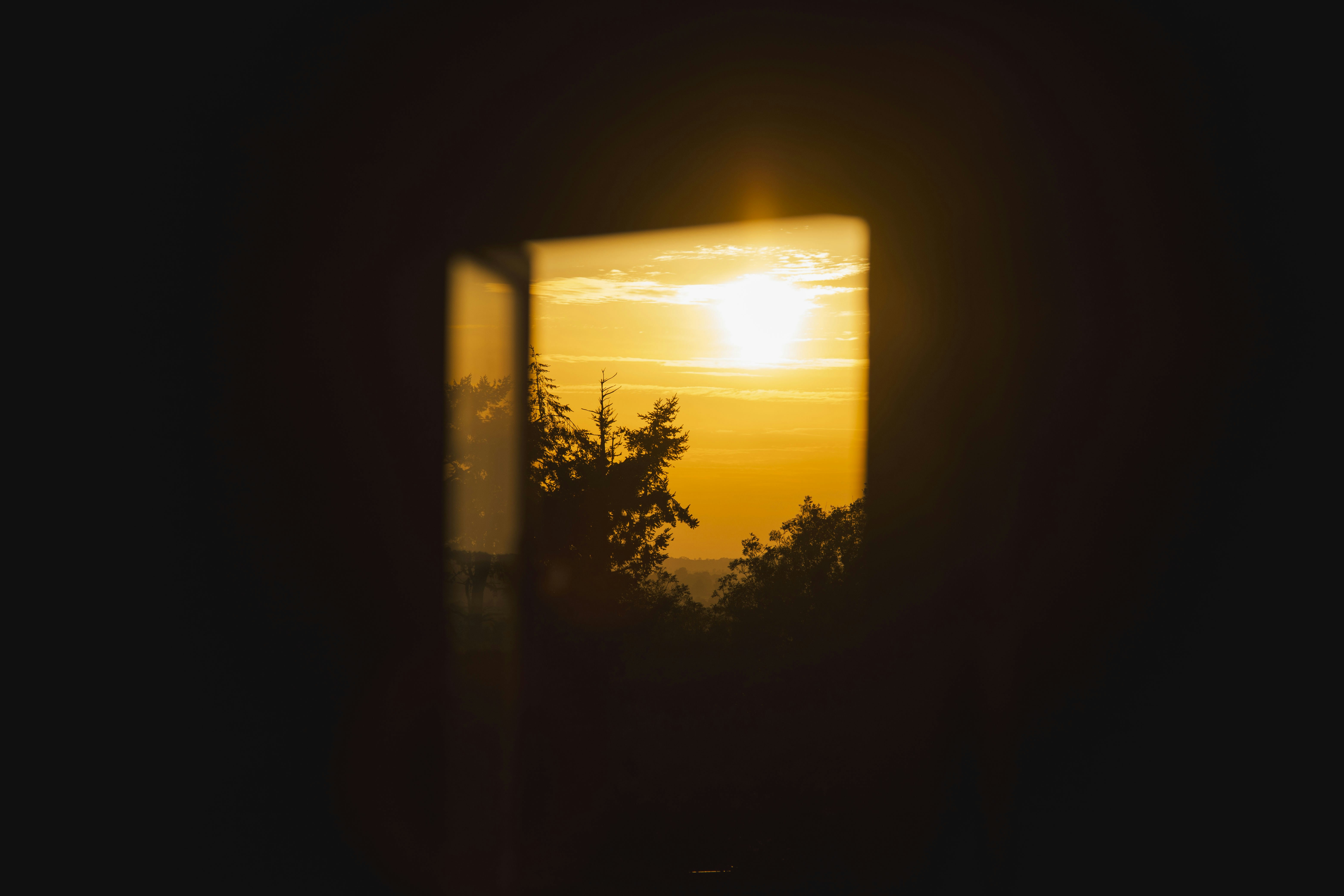 Golden sunset viewed through a window frame.
