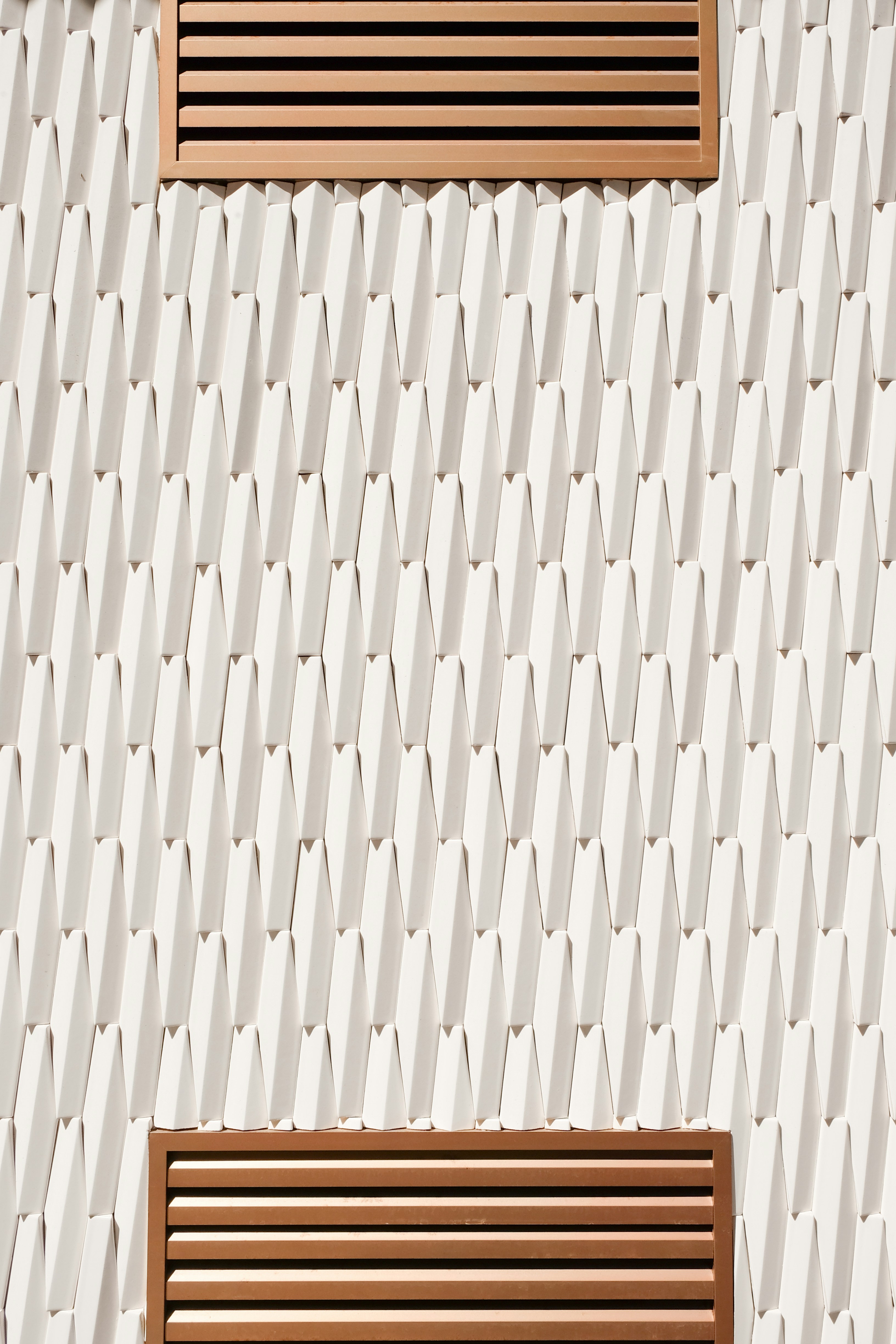 White textured wall with wooden vents