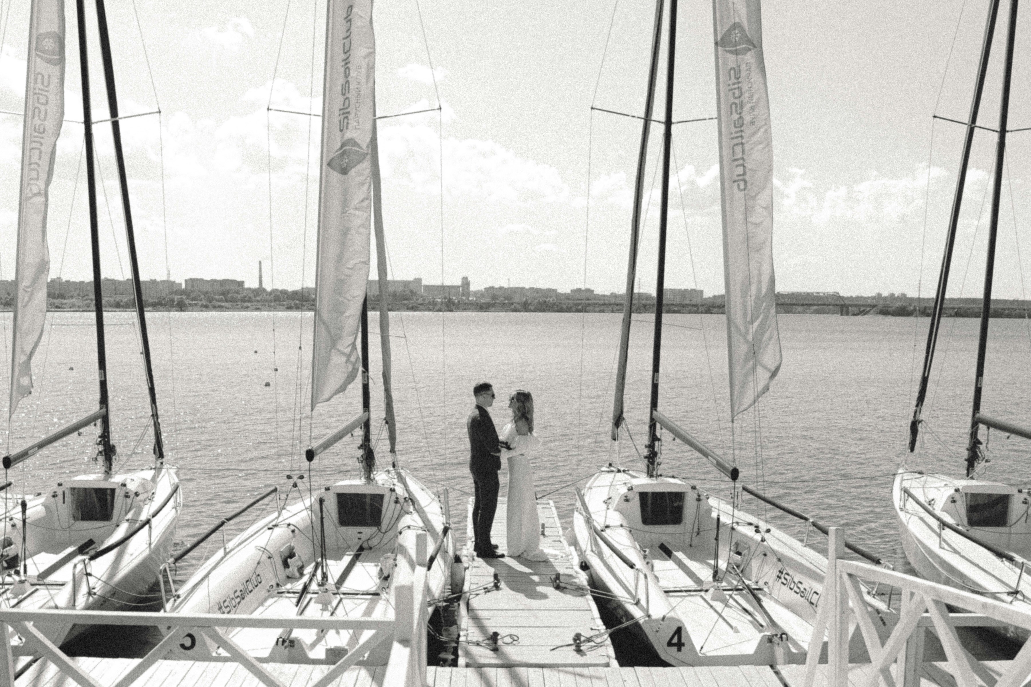 О важном, о любви | Couple standing on dock between sailboats