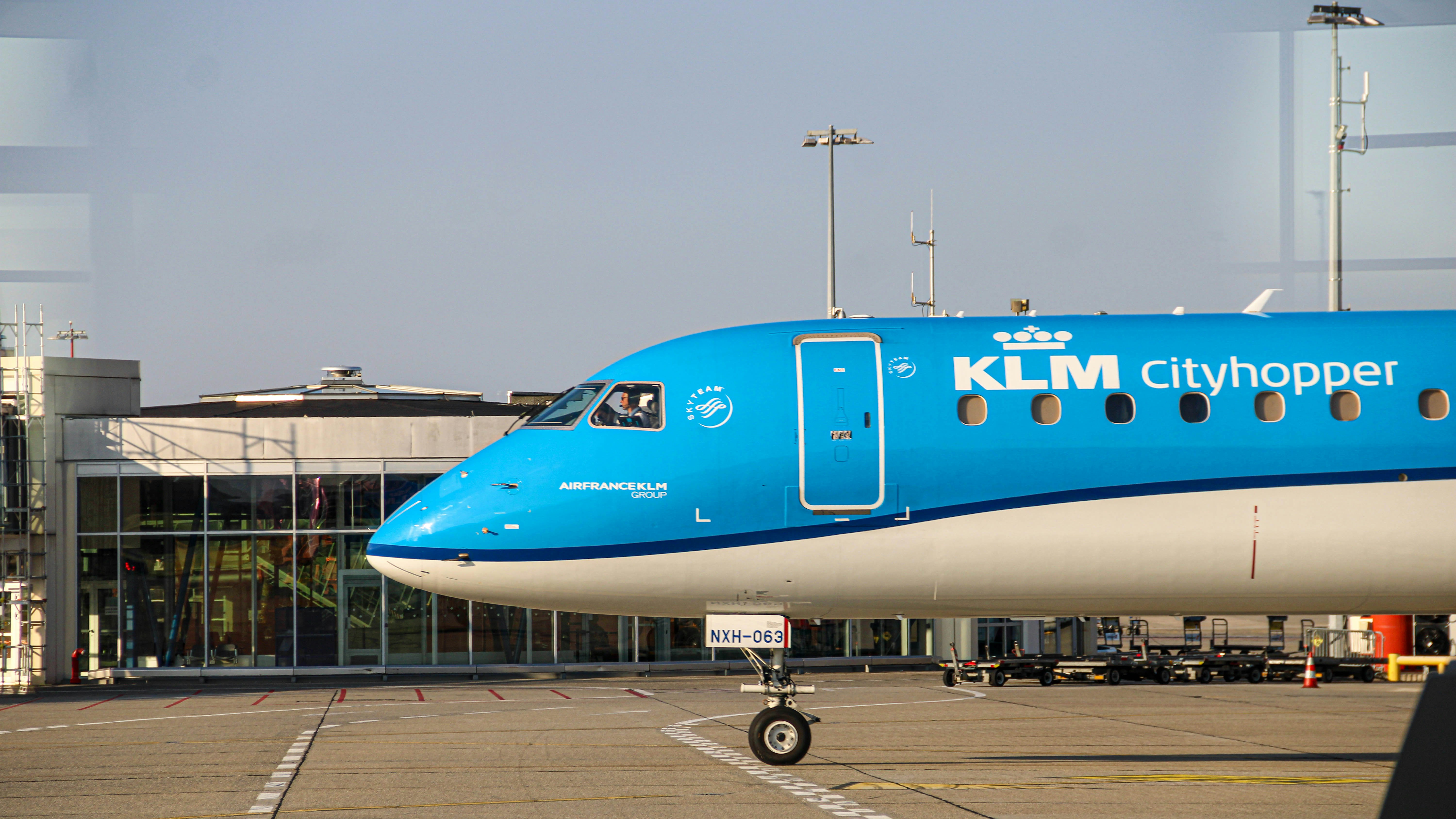 Coastal Blue at the Gate: A KLM Cityhopper Resting by the Boarding Bridge