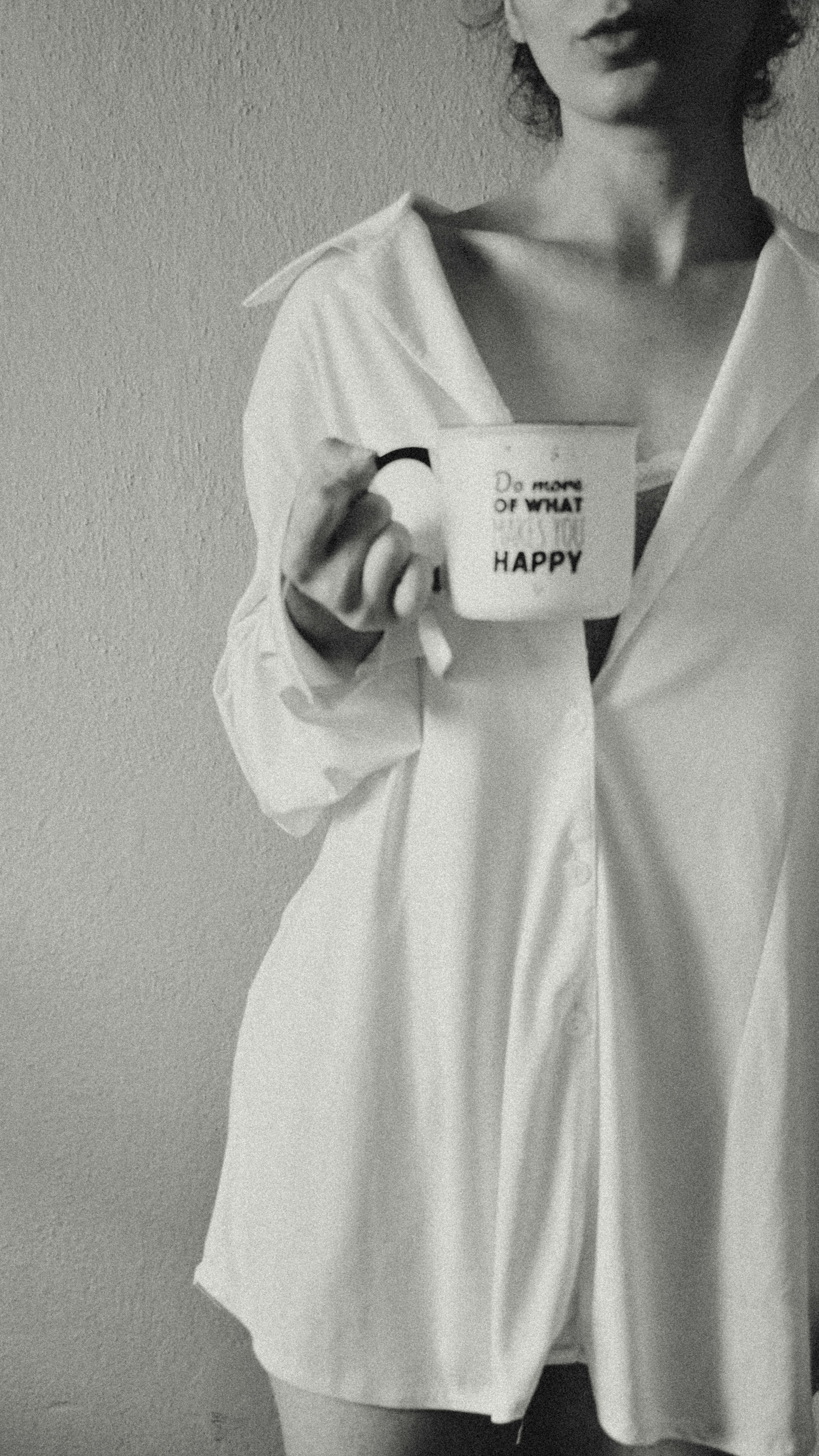 A woman drinking coffee. | Woman in white shirt holding mug with inspirational quote.