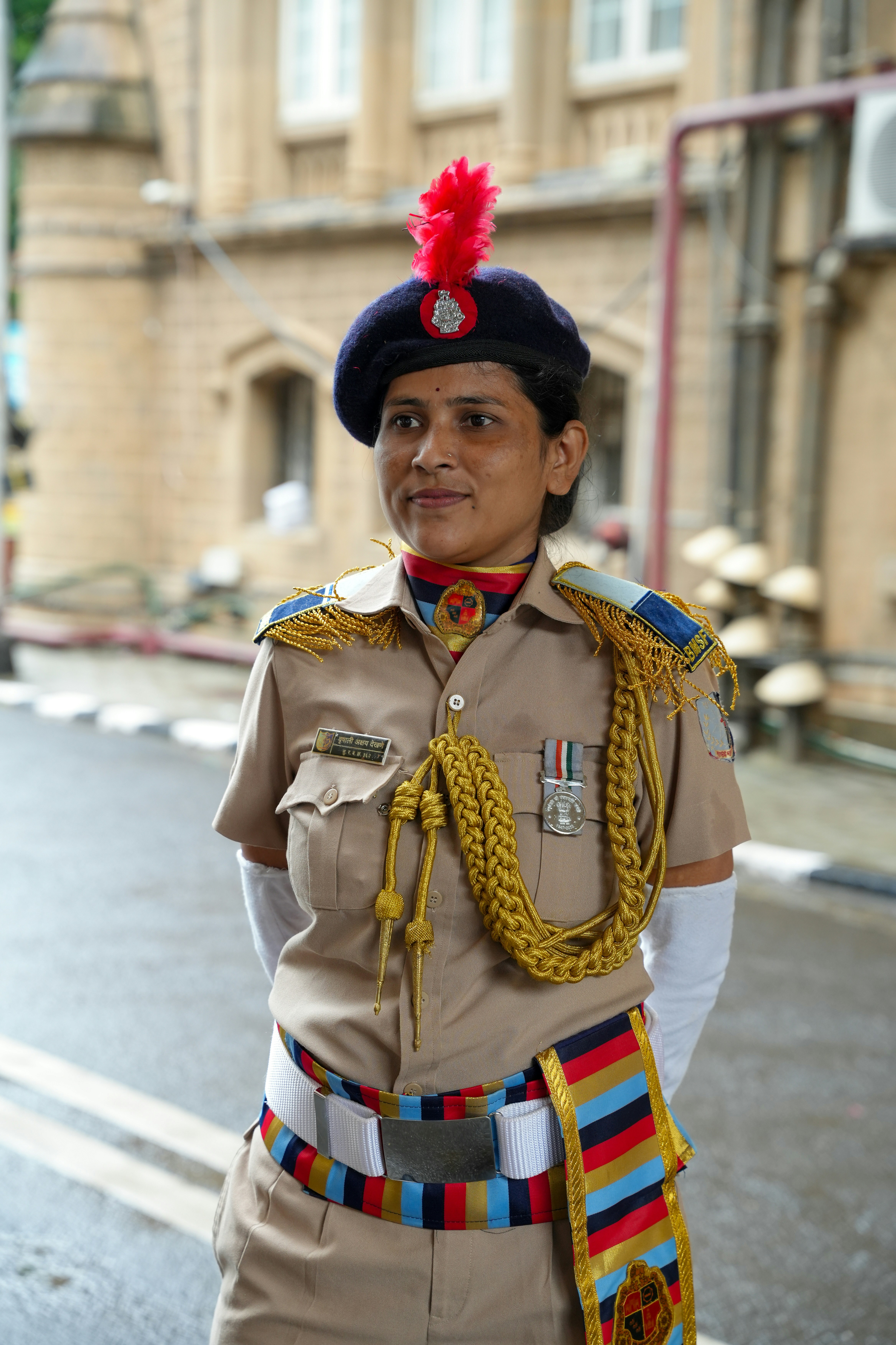 Woman in military uniform with medals and beret.