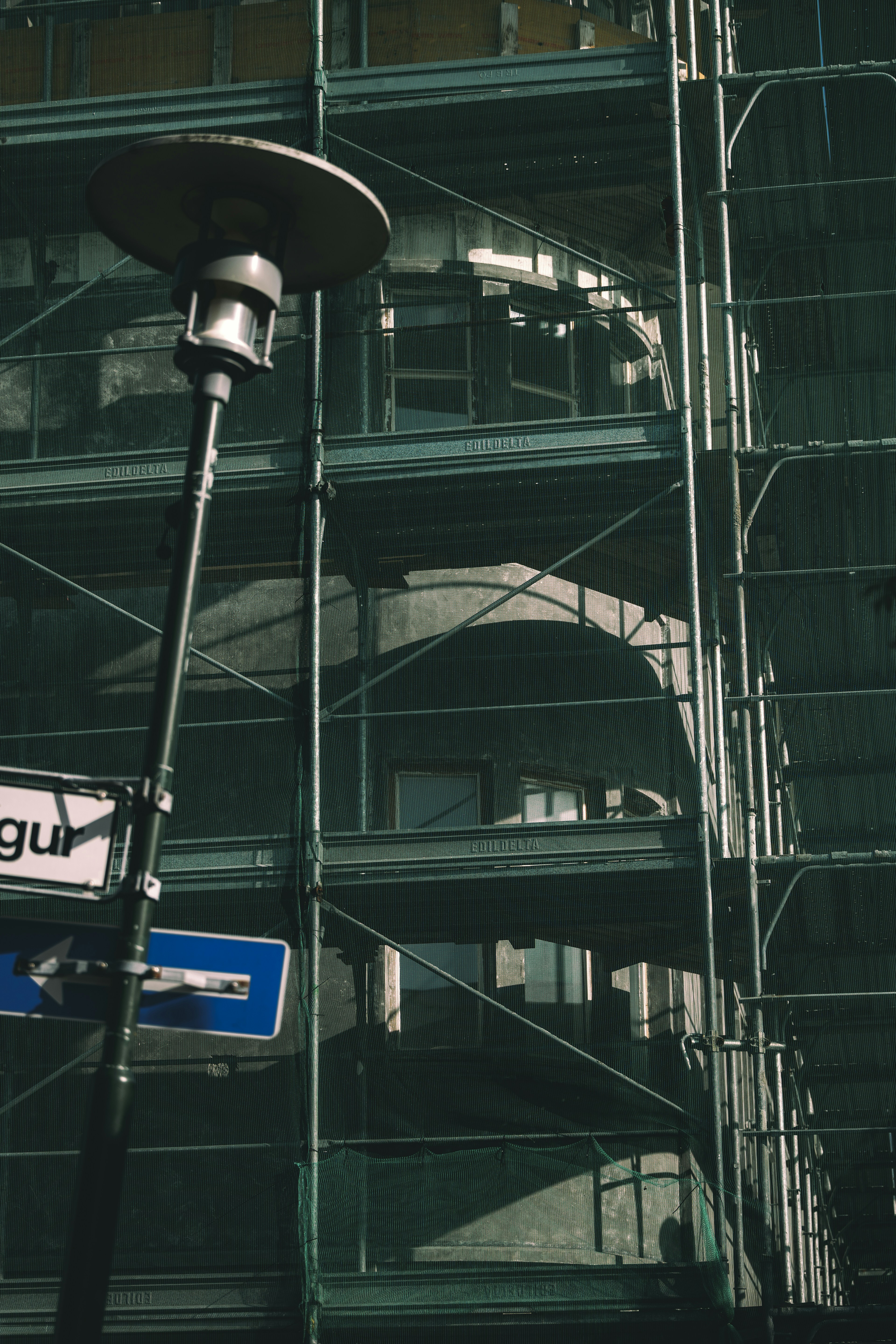 Building under renovation with scaffolding and street lamp.