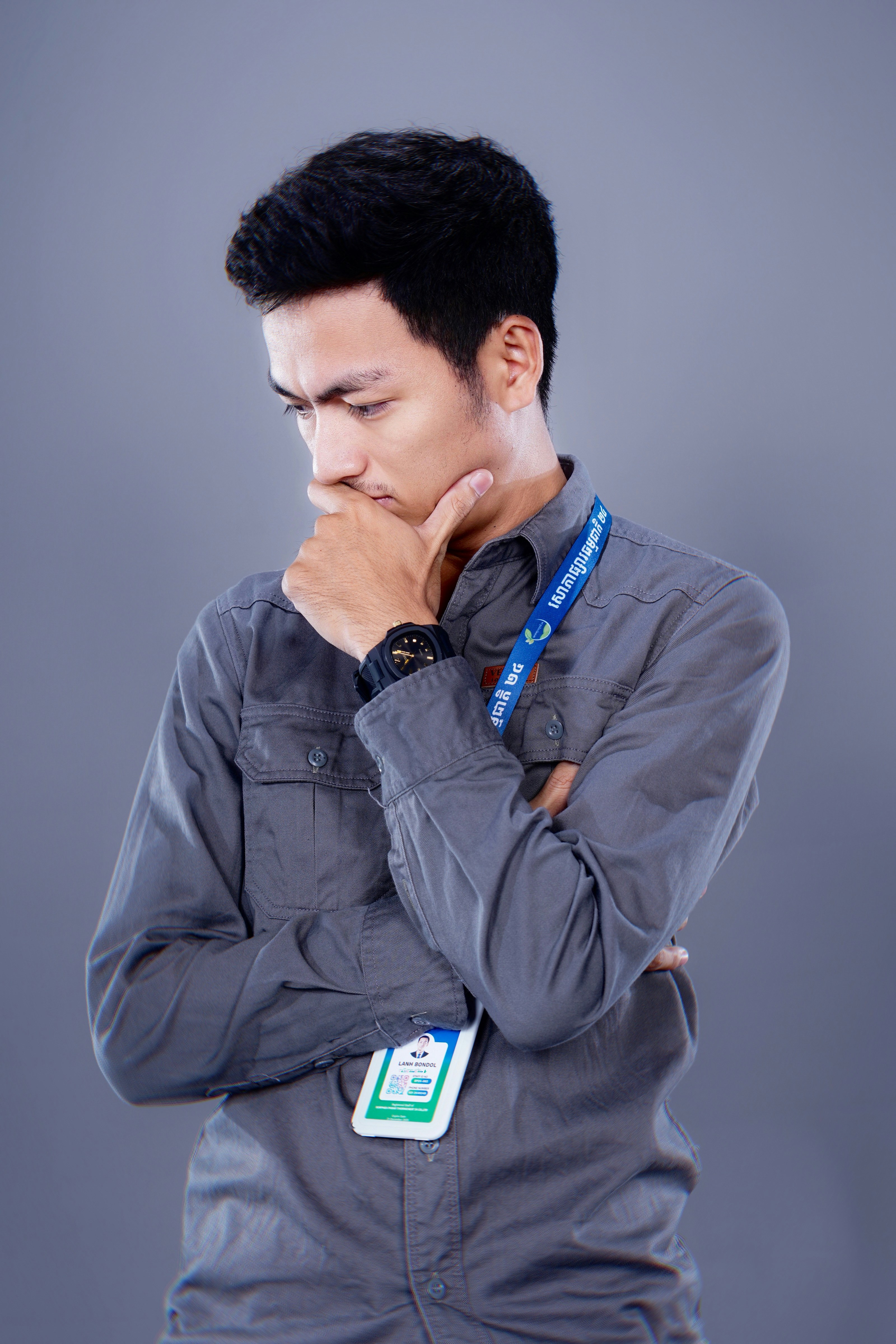 Lanh Bondol | Man in gray shirt thinking with hand on chin