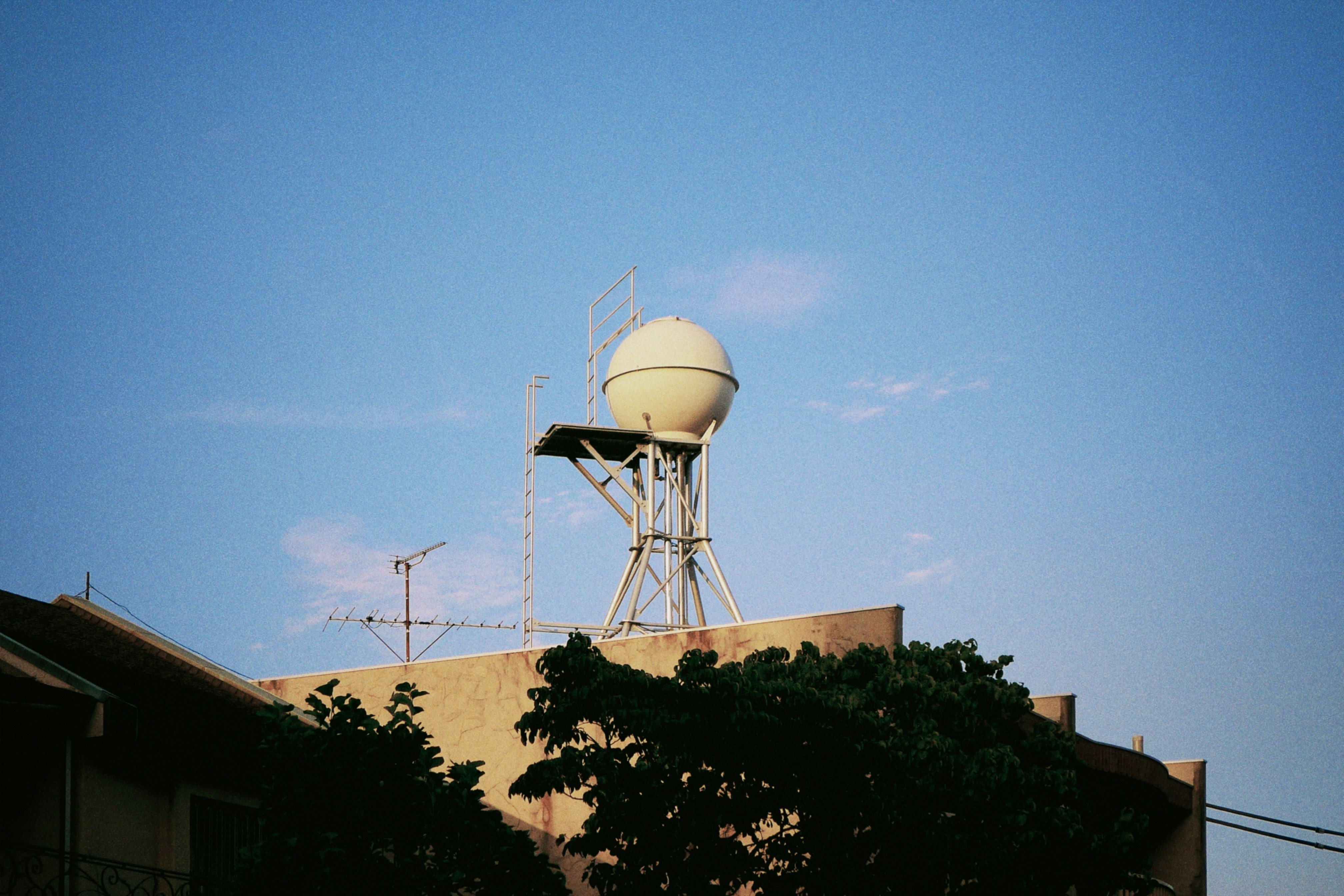 Weather radar dome on a building roof with blue sky